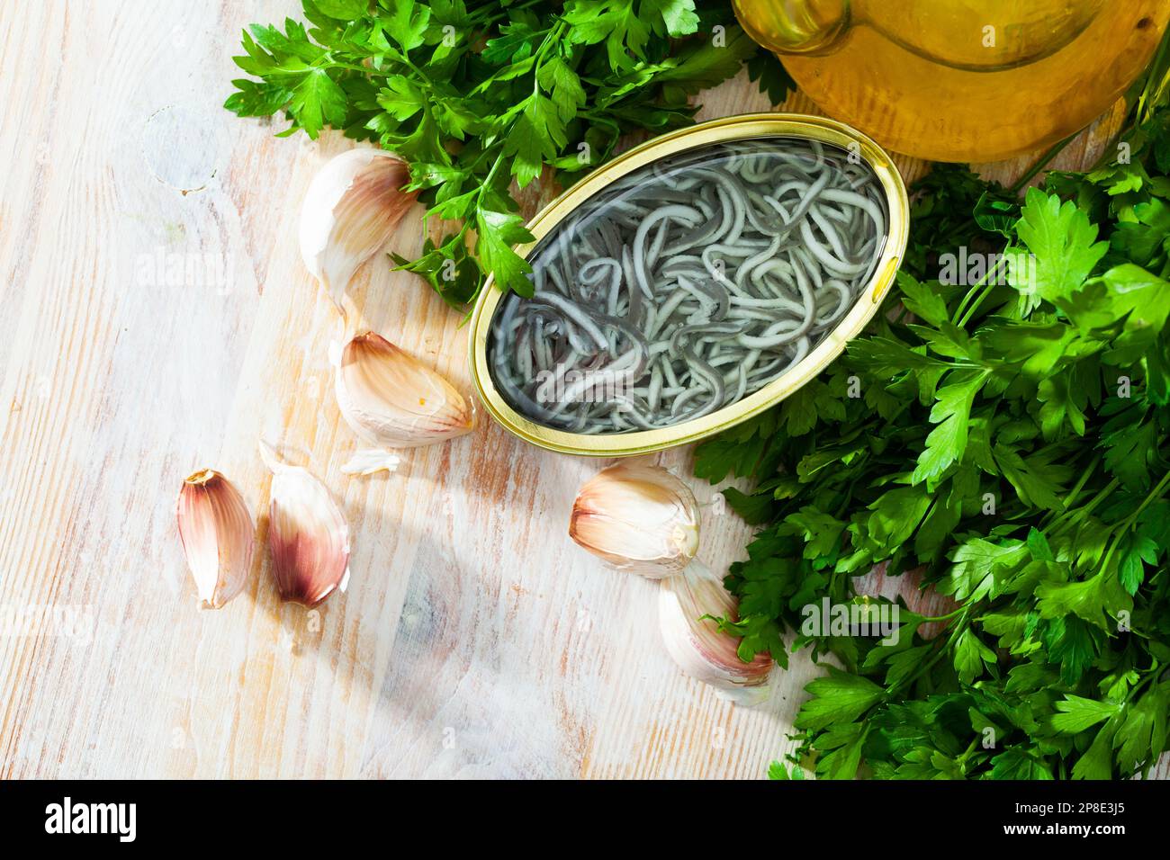 Pickled eels in open tin can with garlic at table Stock Photo - Alamy