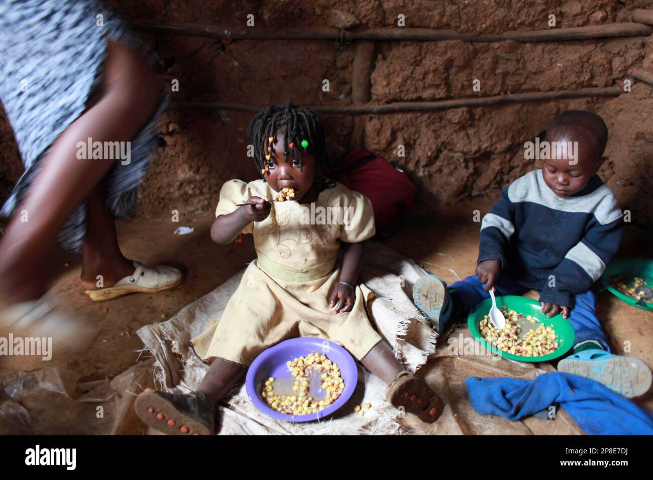 Children eat lunch in a school made from sticks and mud in the Kibera ...