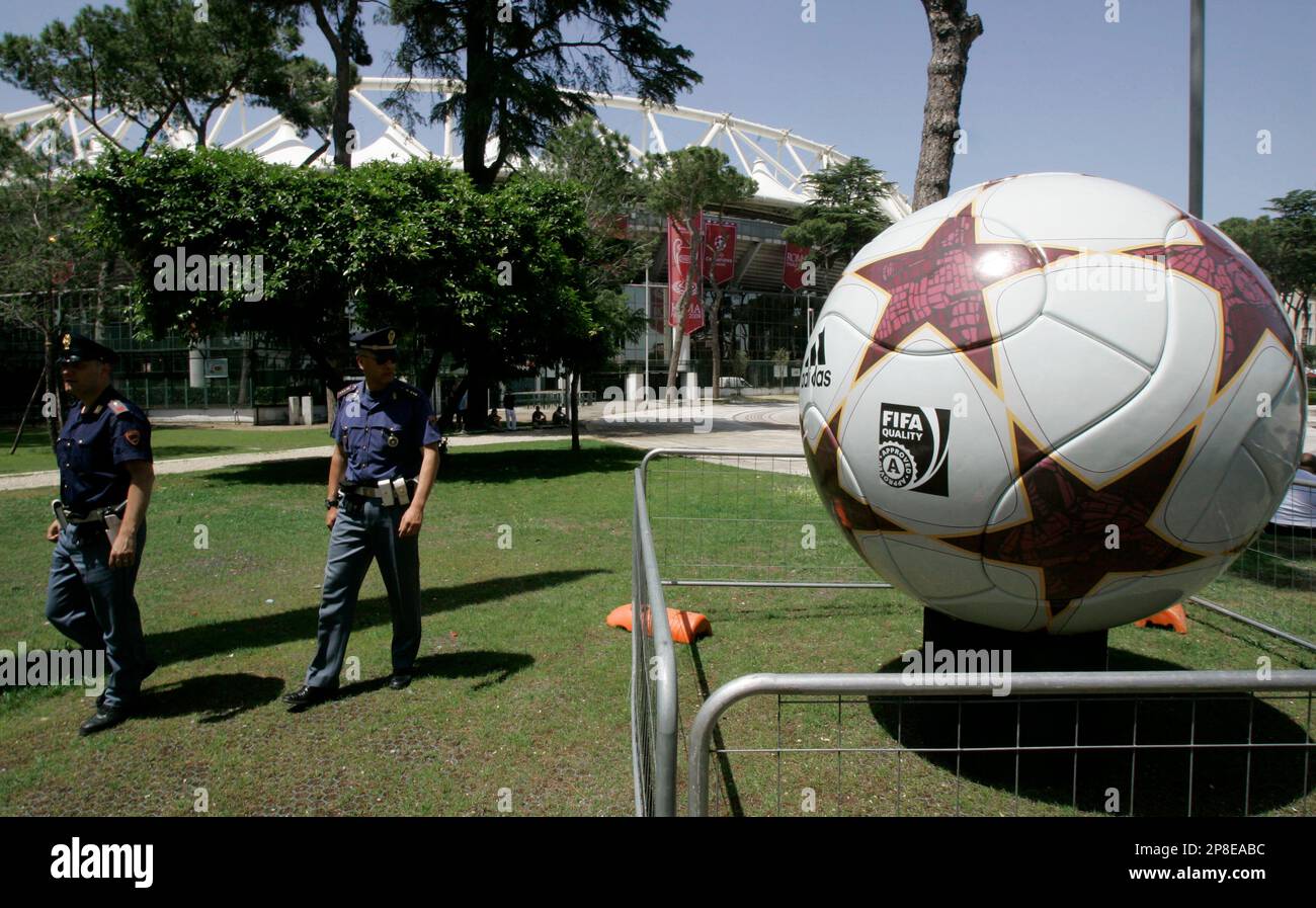 Italian police officers walk past a giant soccer ball as they patrol ...