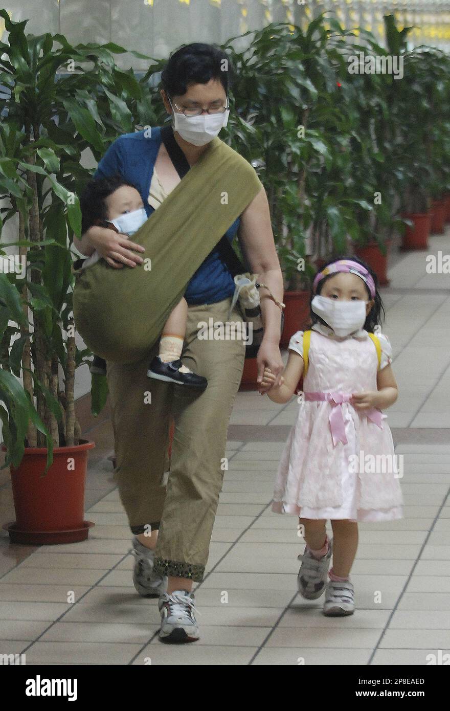 A Taiwanese mother walks with her two children toward a Taipei Mass ...