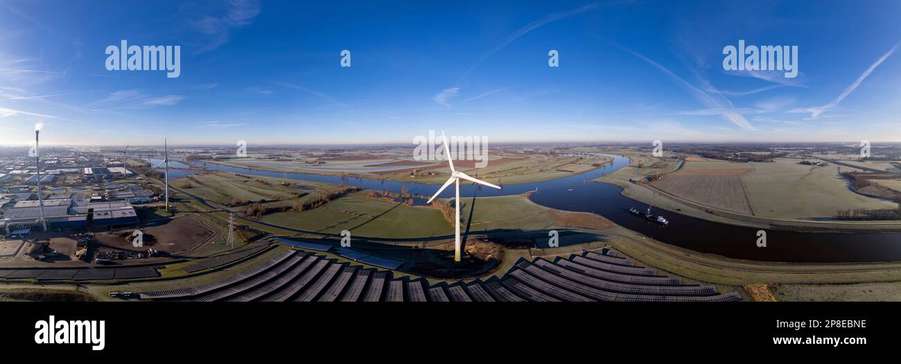 Wide panorama of wind turbine and solar panels in industrial landscape ...