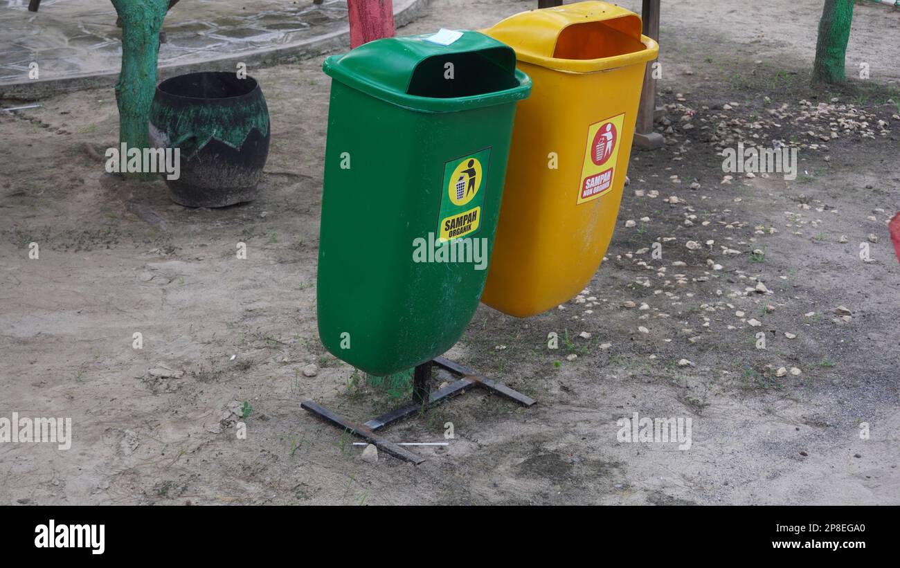 Yellow and blue garbage trash bin. Selective focus separator wet and ...