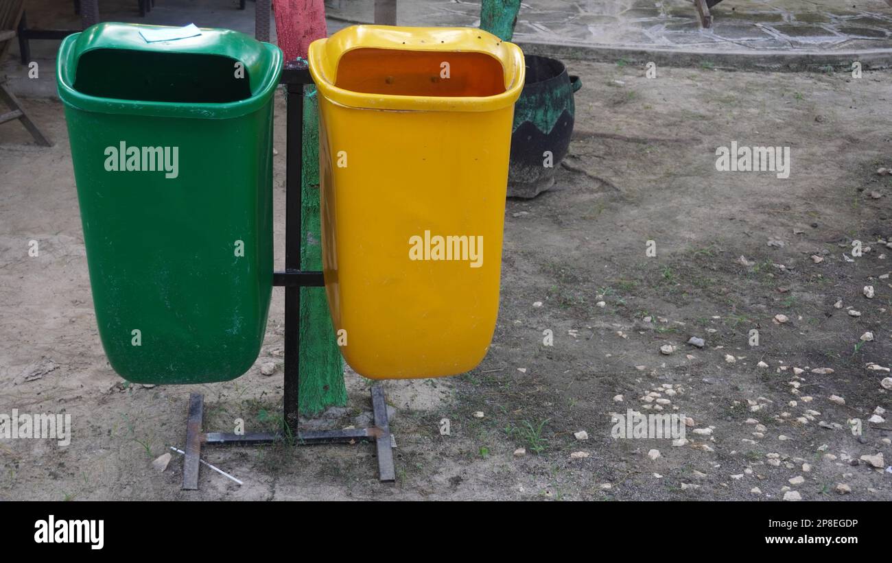 Yellow and blue garbage trash bin. Selective focus separator wet and ...