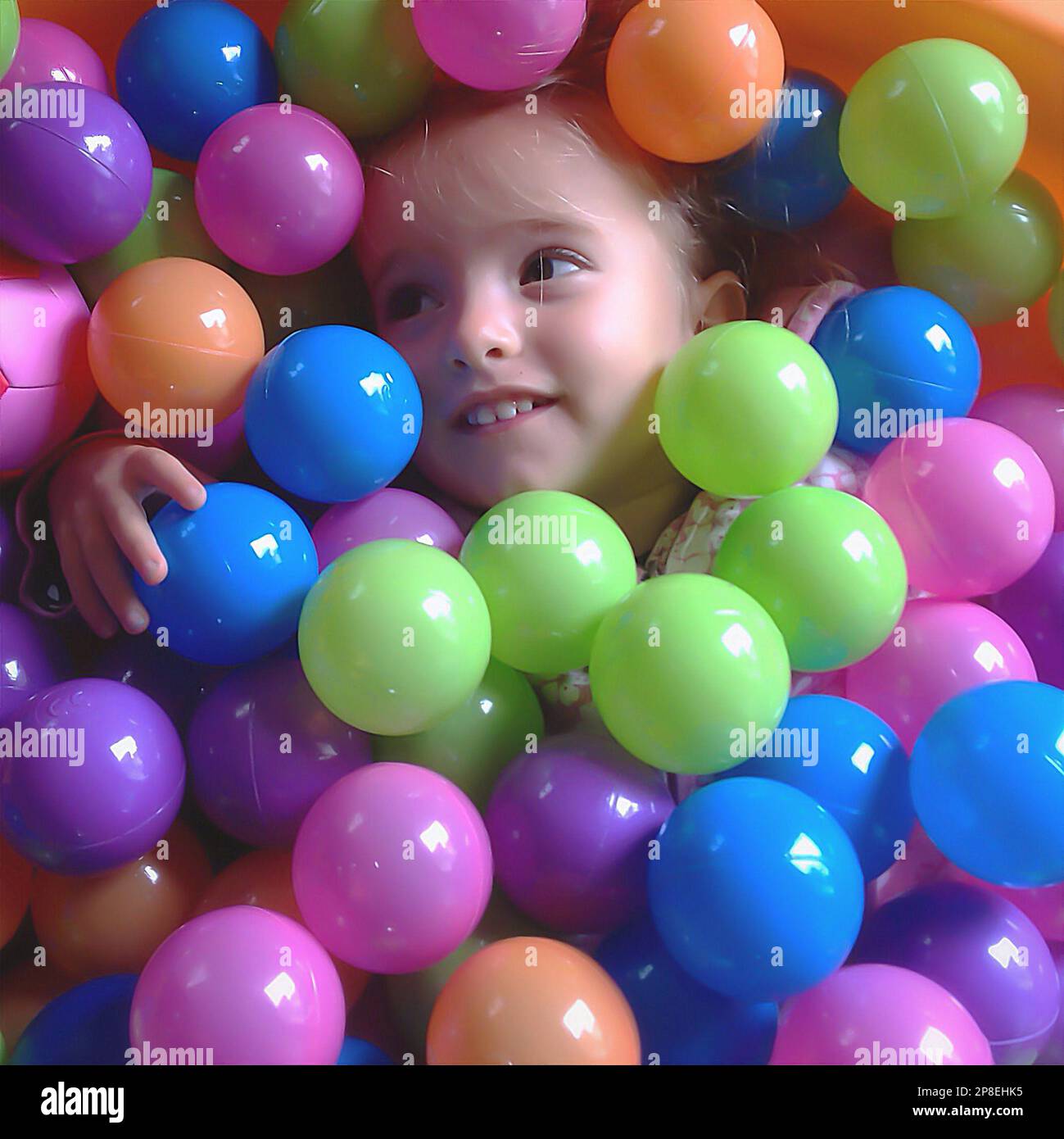 Overhead view of a smiling girl lying in a ball pit Stock Photo - Alamy