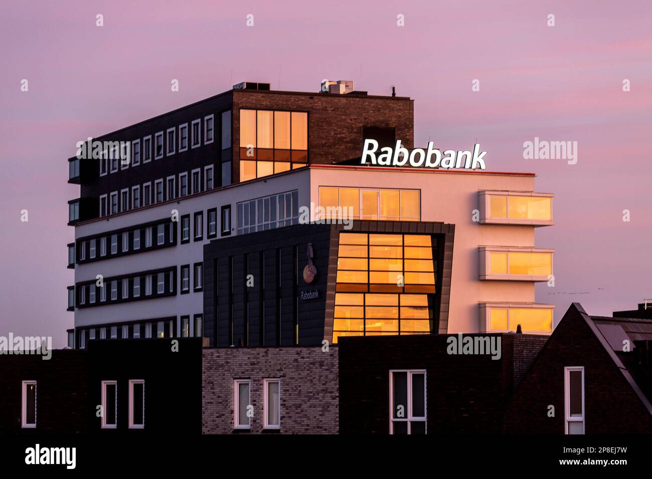 Dutch farmers bank Rabobank at sunrise with warm orange sunlight ...