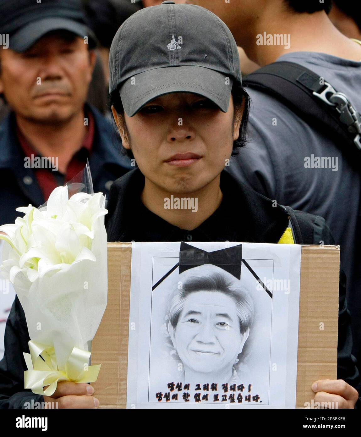 A South Korean woman holds a picture of former President Roh Moo-hyun ...