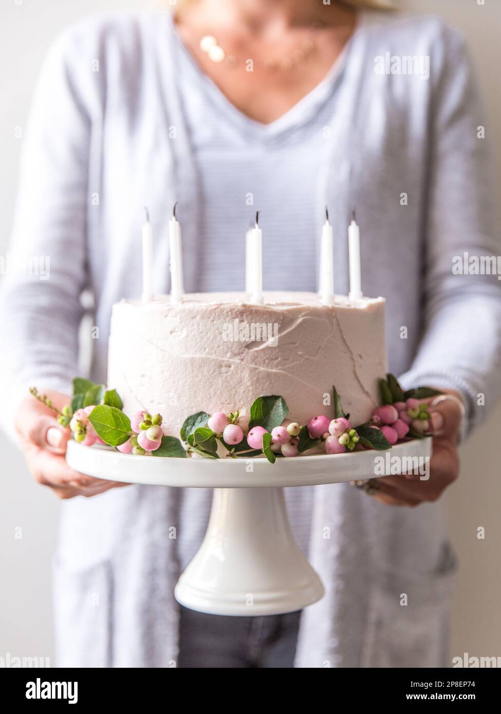 Close-up of a woman carrying a chocolate birthday cake with rose water ...