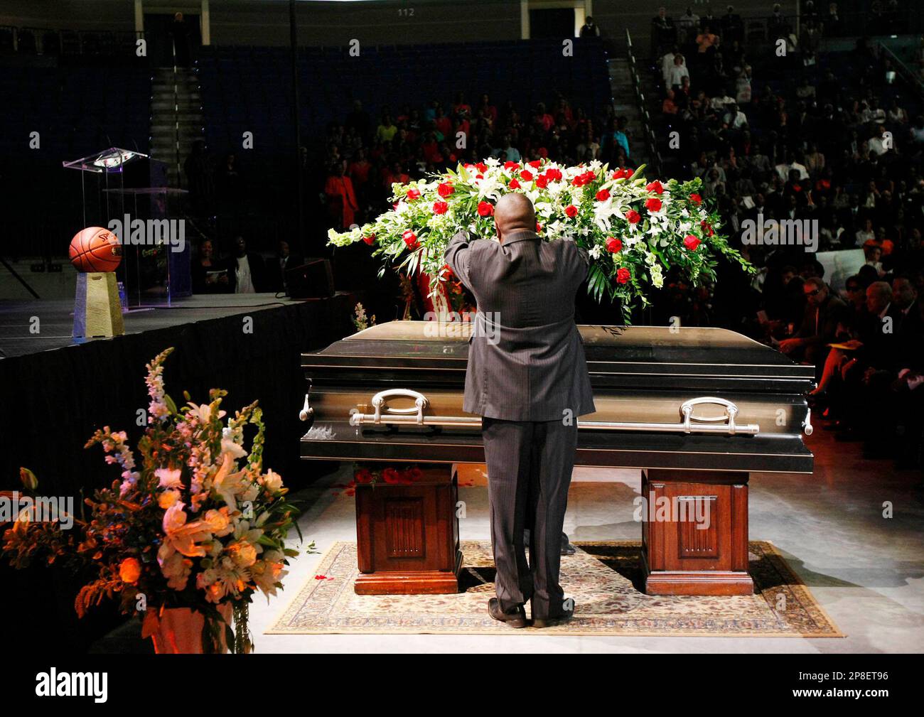 Flowers are placed on the casket containing the body of Wayman Tisdale ...