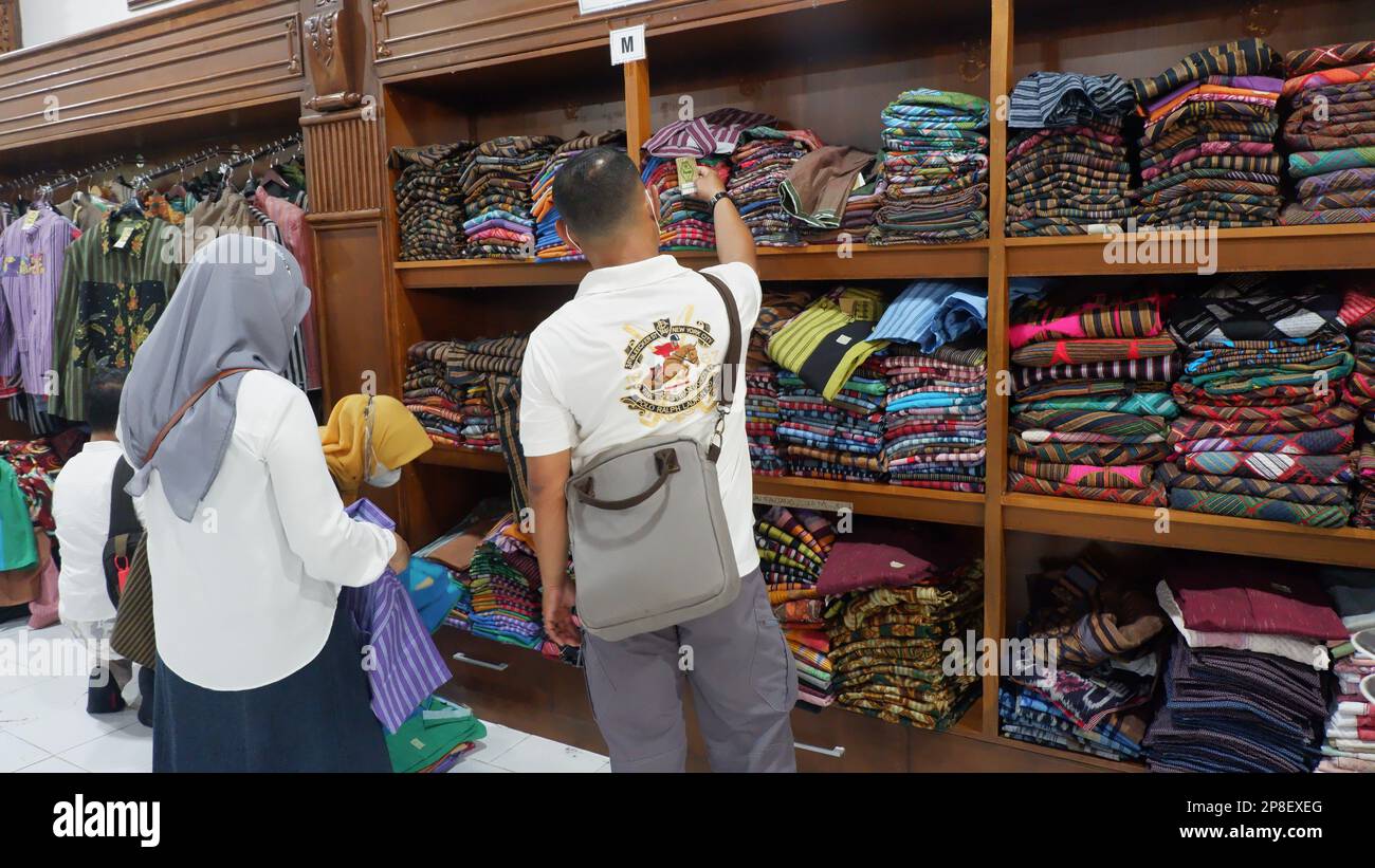 many people are shopping in batik clothes shop. Batik is Indonesian ...