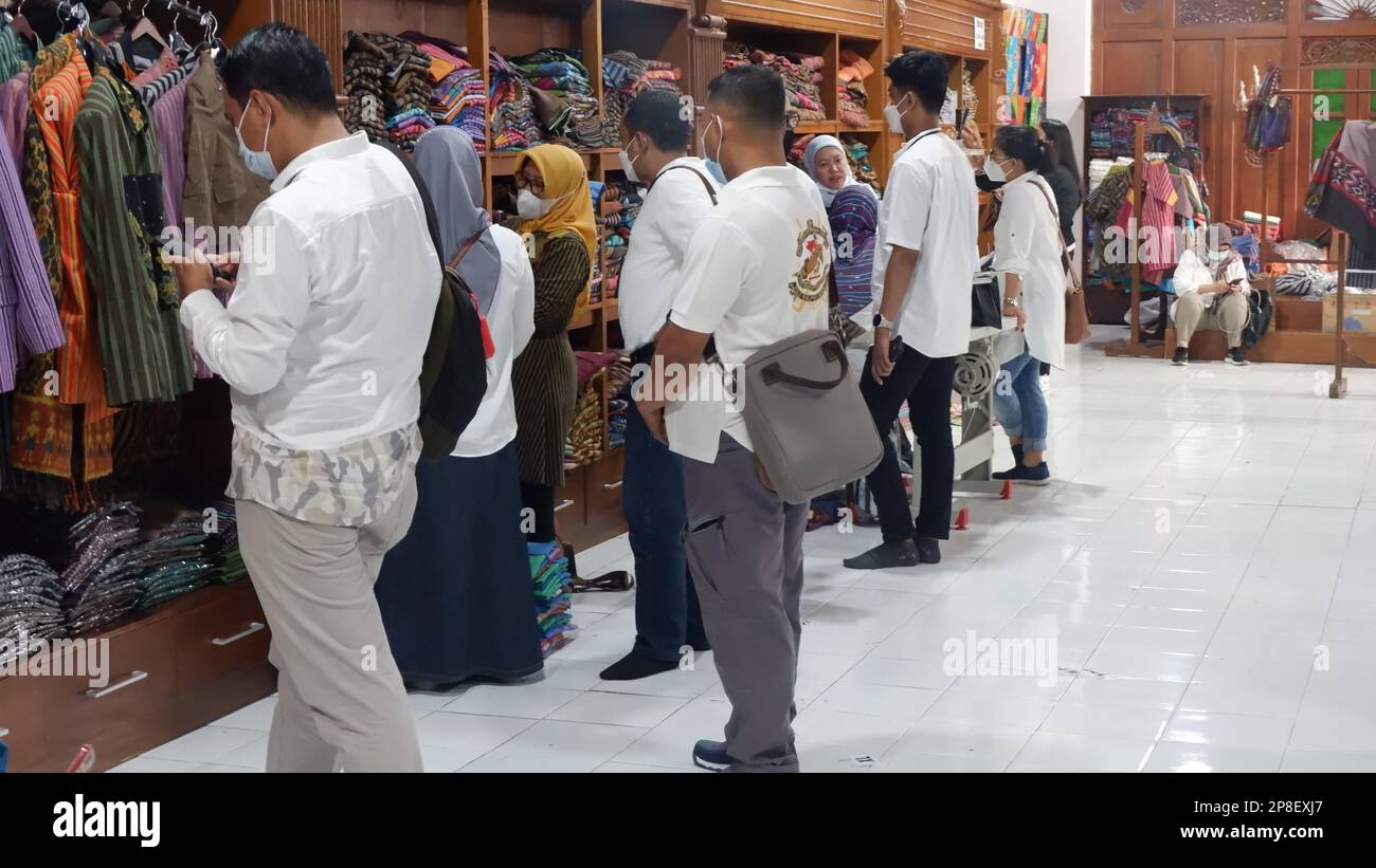 many people are shopping in batik clothes shop. Batik is Indonesian ...