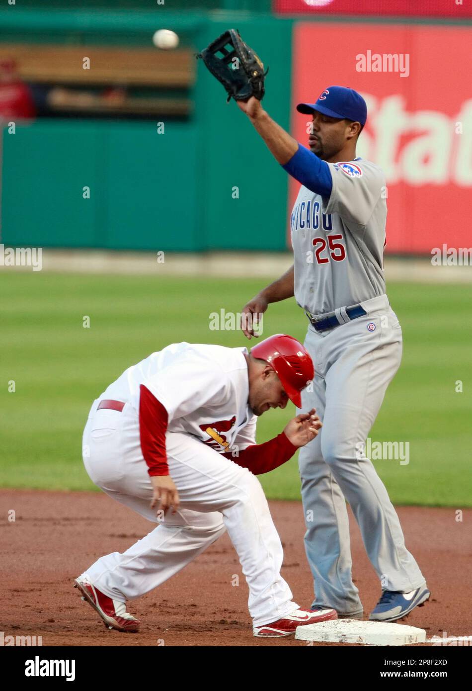 St. Louis Cardinals' Yadier Molina ducks back safely at first as ...