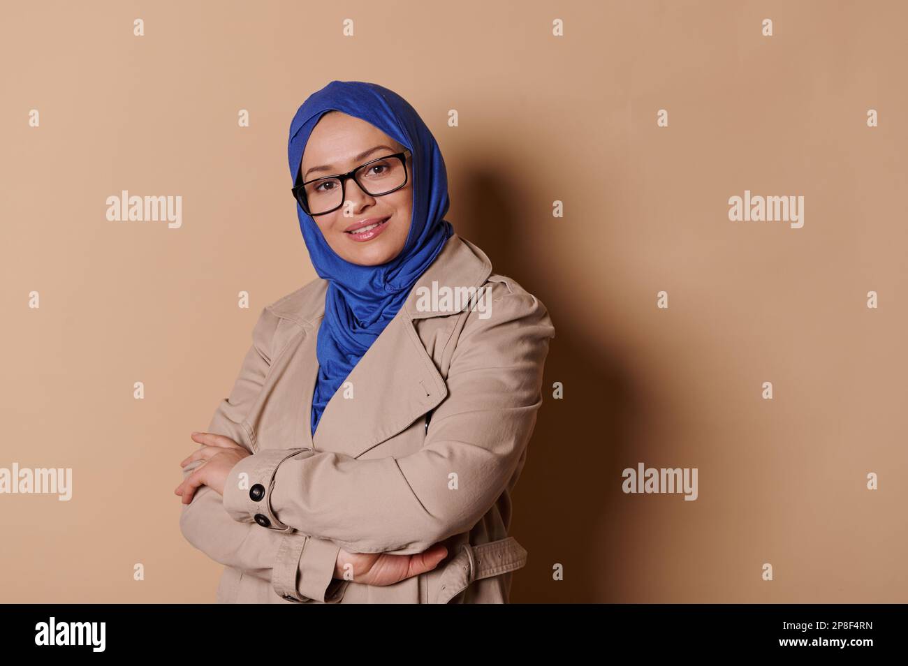 Smiling Muslim woman in elegant strict outfit, blue hijab and stylish ...