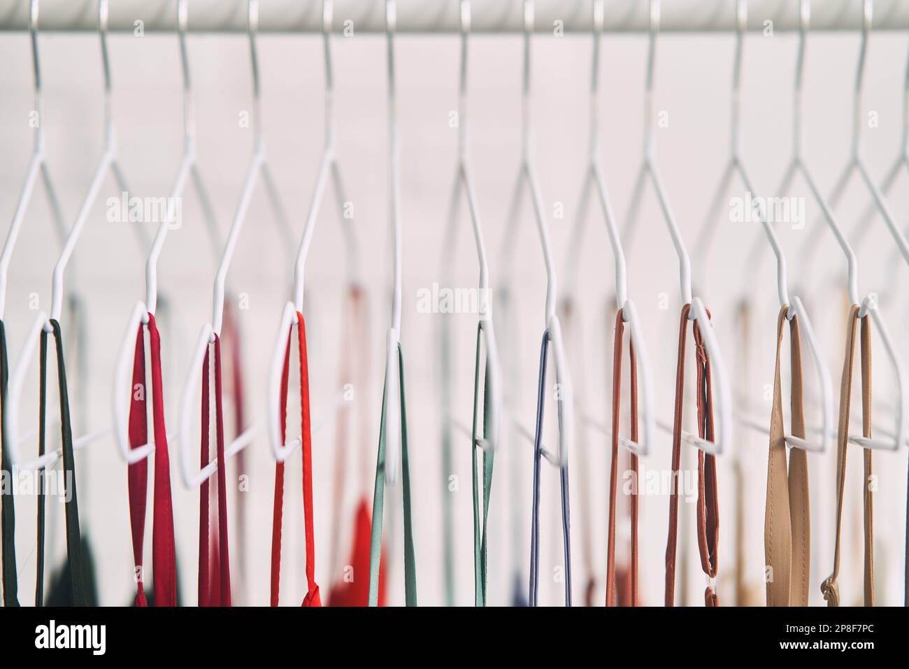 Multi-colored dresses hang on hangers in the store. Sale of women's ...