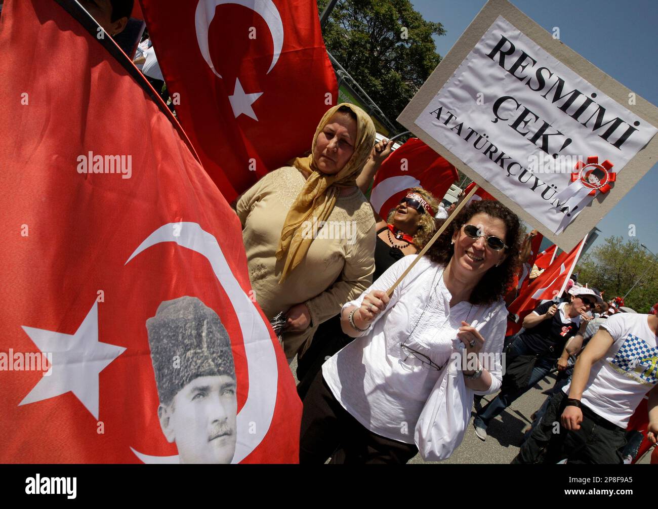 A woman holds a banner theat reads " Take my pictures, I am Ataturkist" as tens of thousands ...
