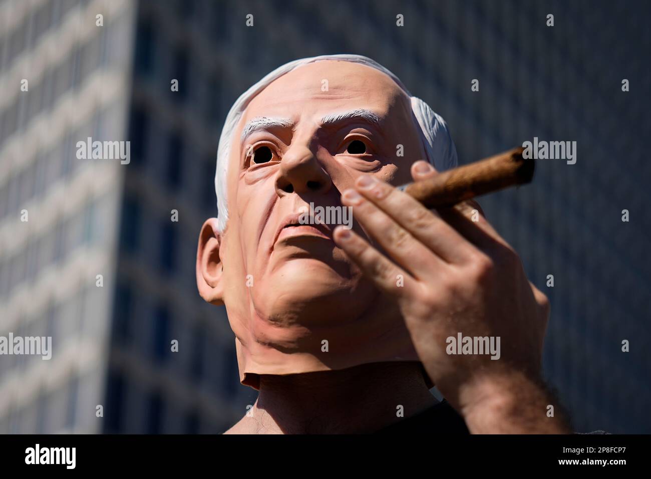 An Israeli demonstrator wears a mask depicting Israeli Prime Minister ...