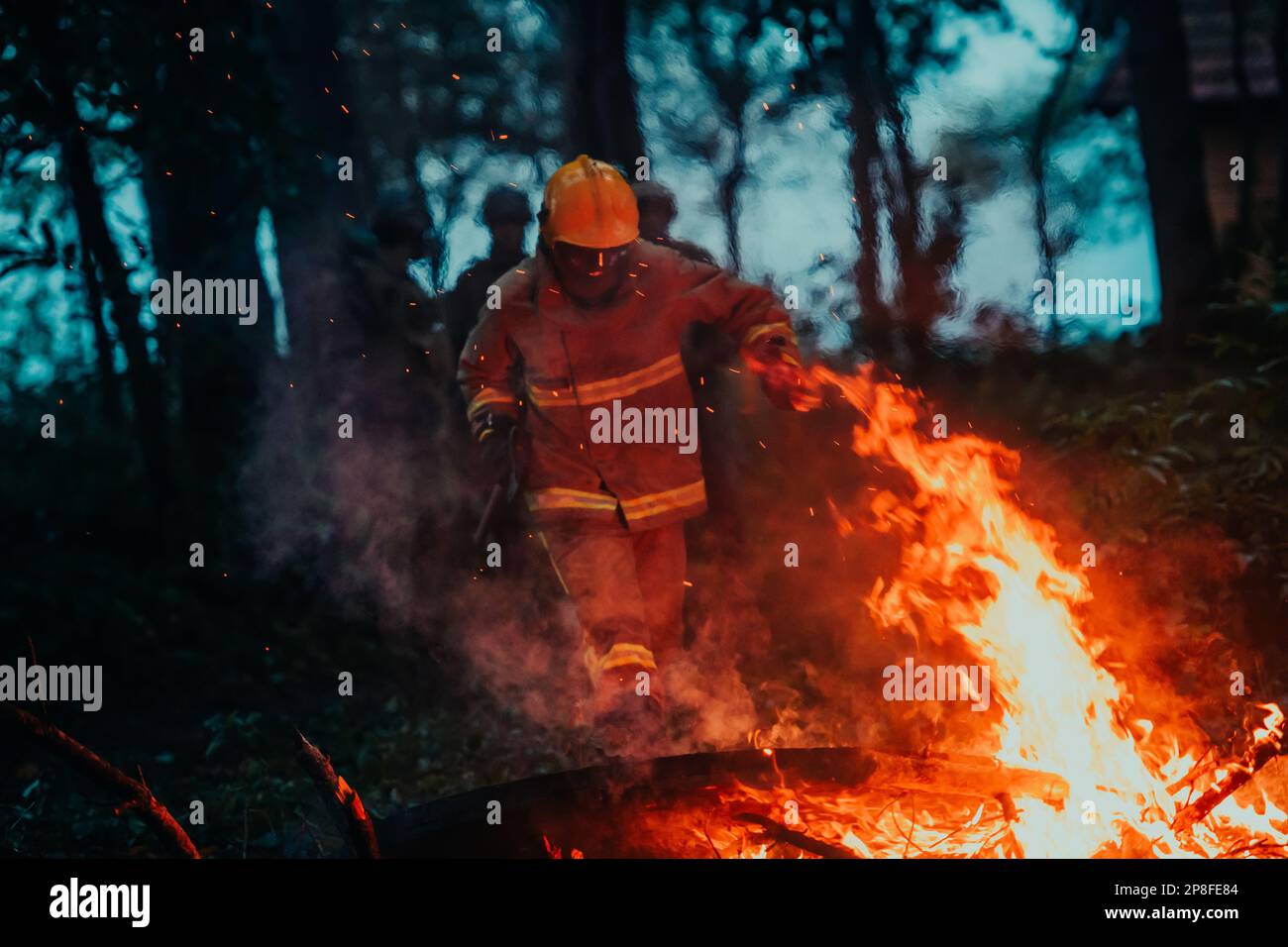 firefighter hero in action danger jumping over fire flame to rescue and ...