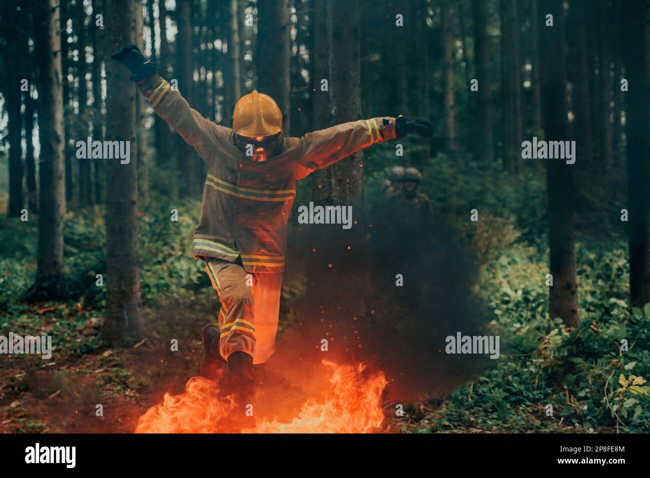 firefighter hero in action danger jumping over fire flame to rescue and ...