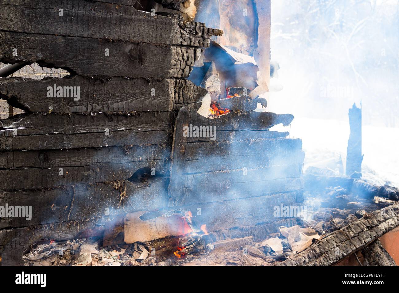 A wooden building burning down after a fire, a charred black wall and ...