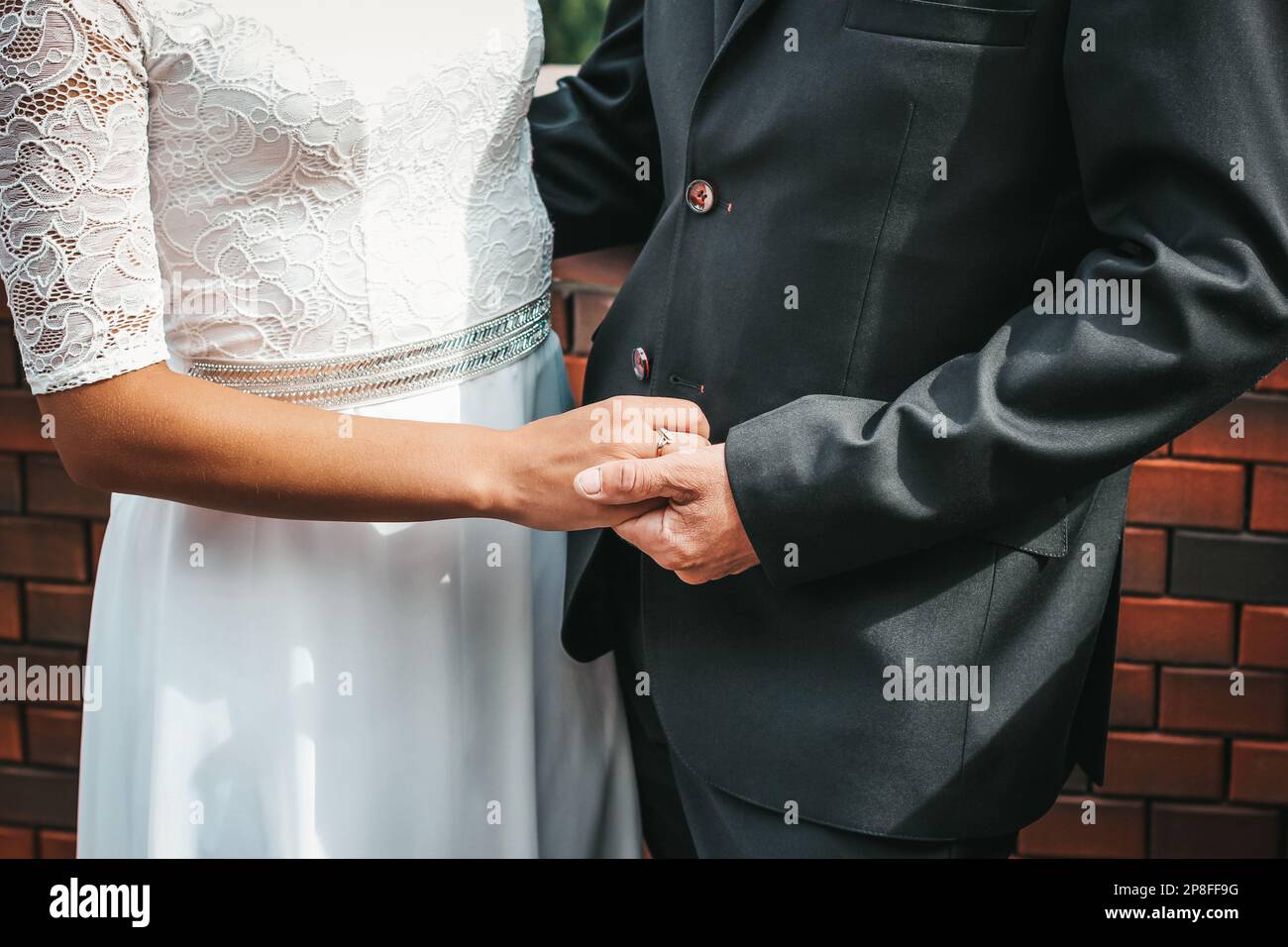 Close-up photo of the hands of the bride and groom, decorated with ...