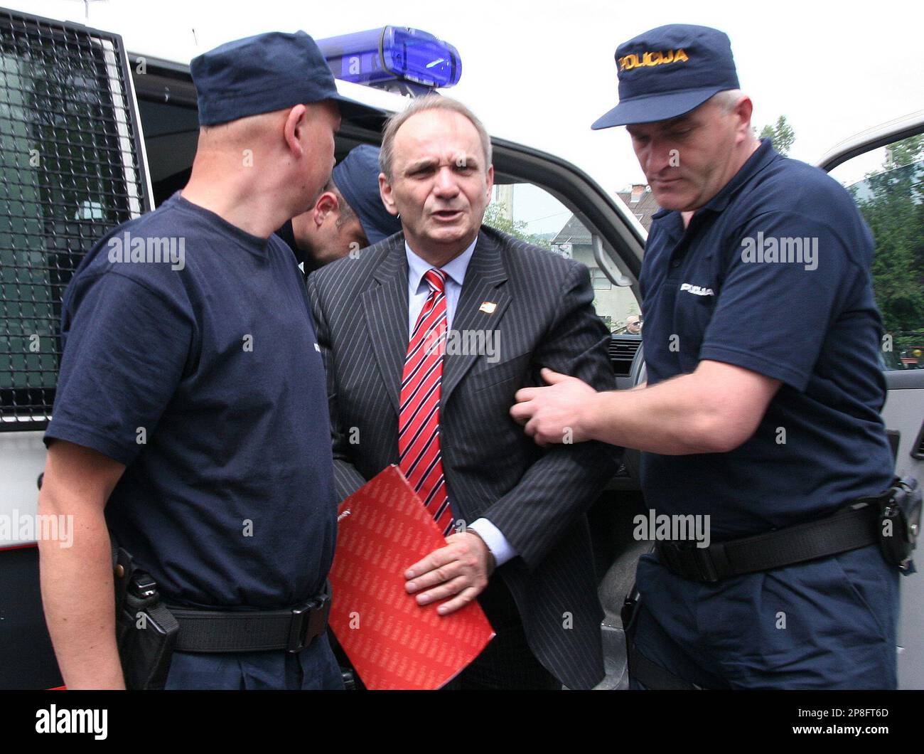 Two Bosnian police officers taking Branimir Glavas to the Office of the ...