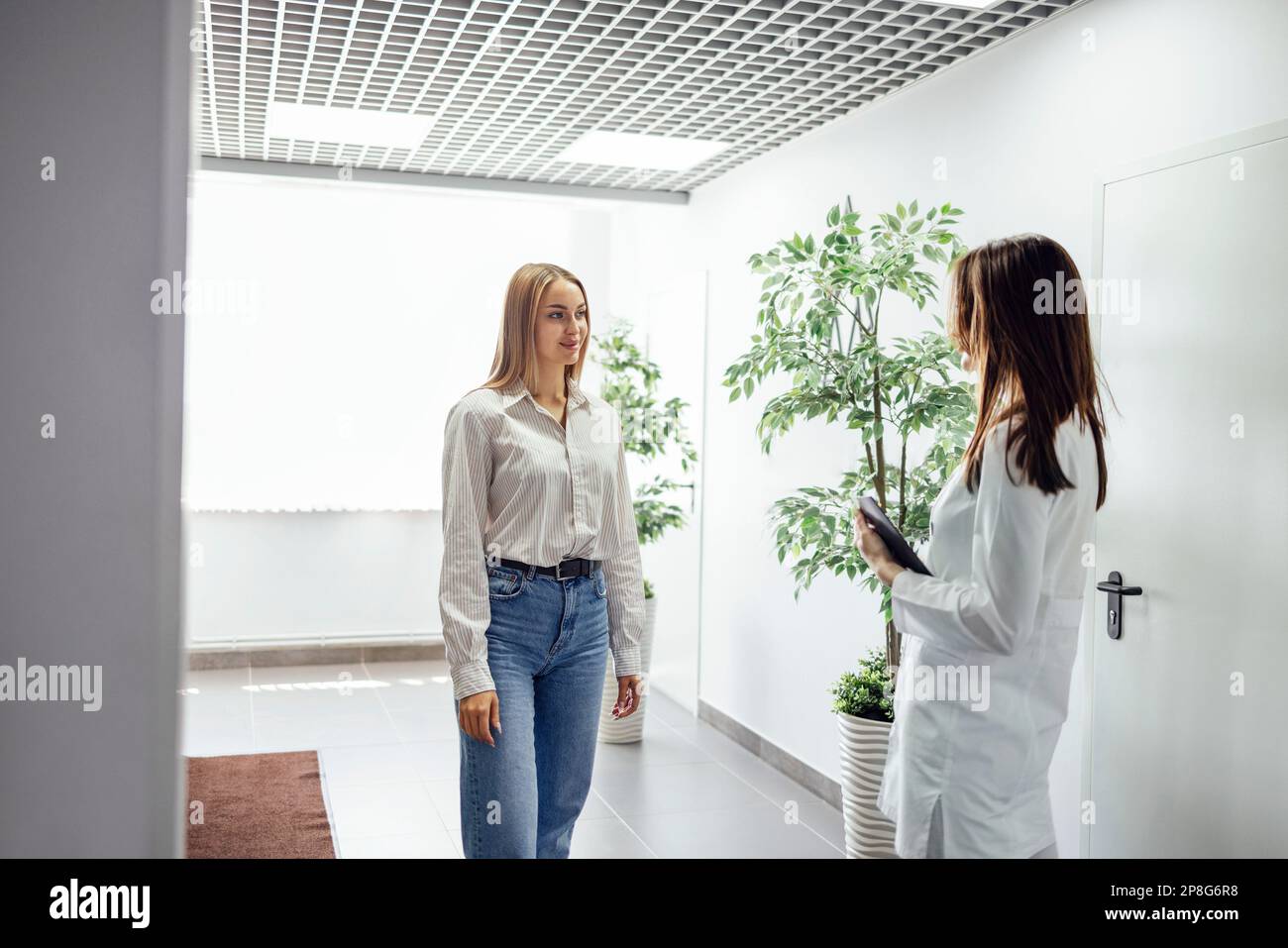 Smiling female client communicates with reception woman in a beauty ...
