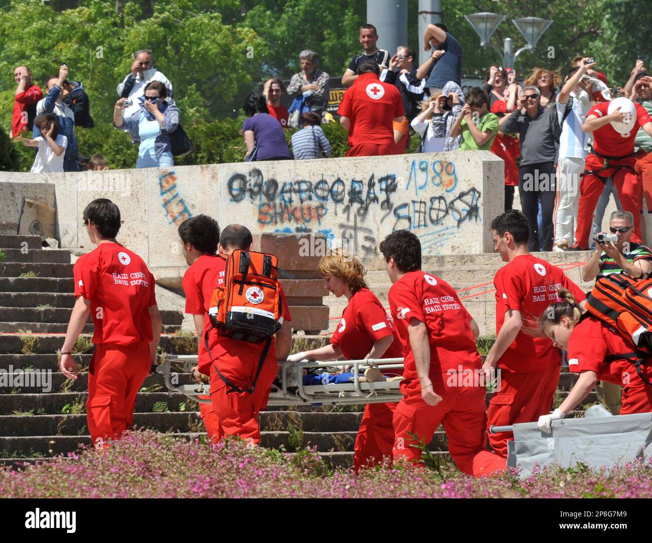 Red Cross rescue team members attend to an acting injured person ...