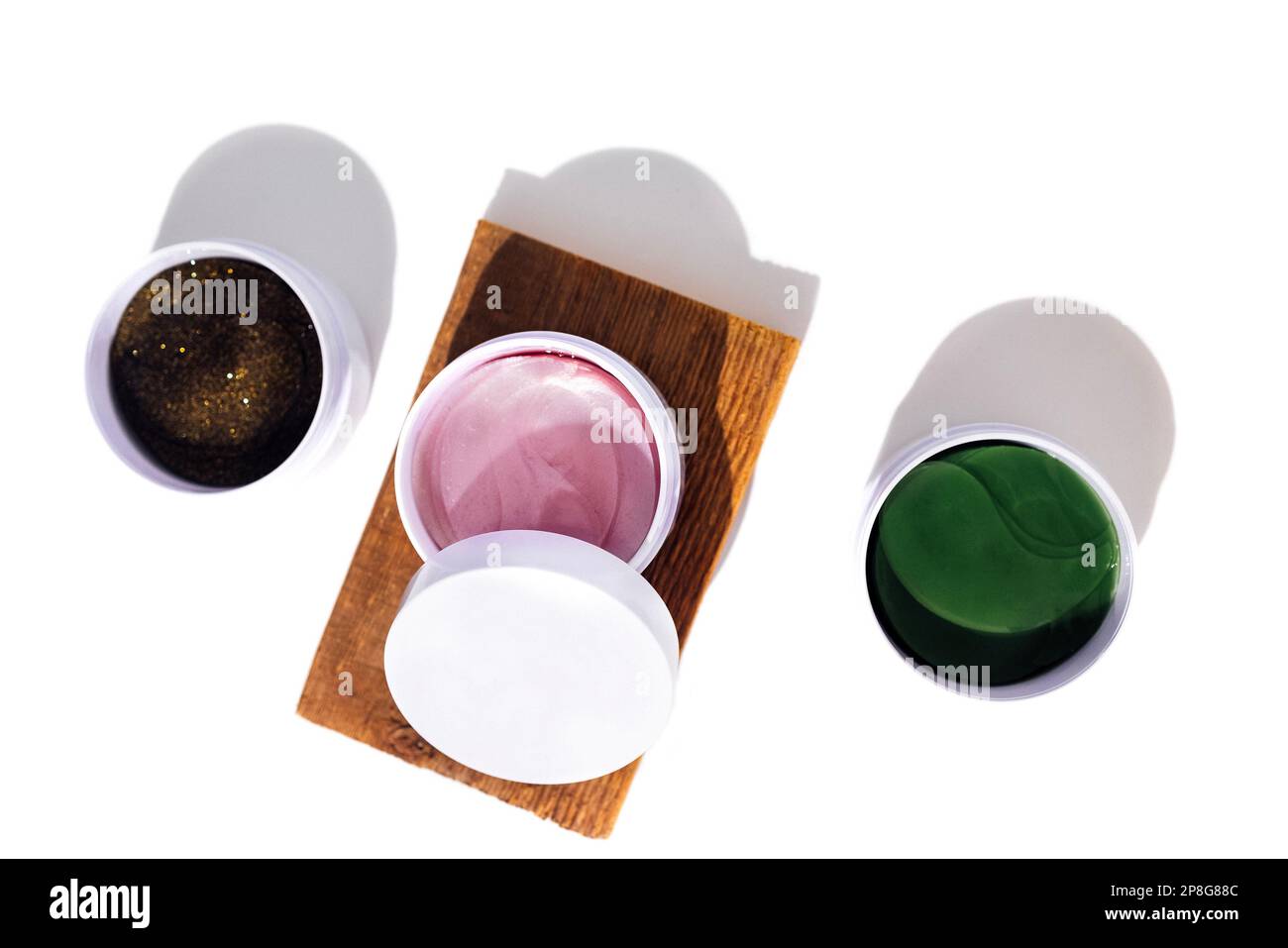 Plastic jar with green collagen eye patches on cork stage. Aloe plant ...