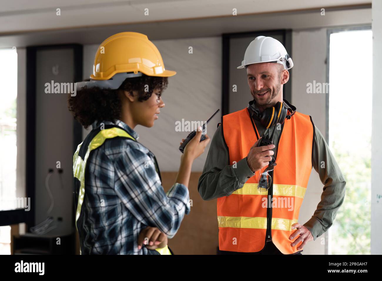 Female male engineers holding walkie talkie radios and inspecting ...