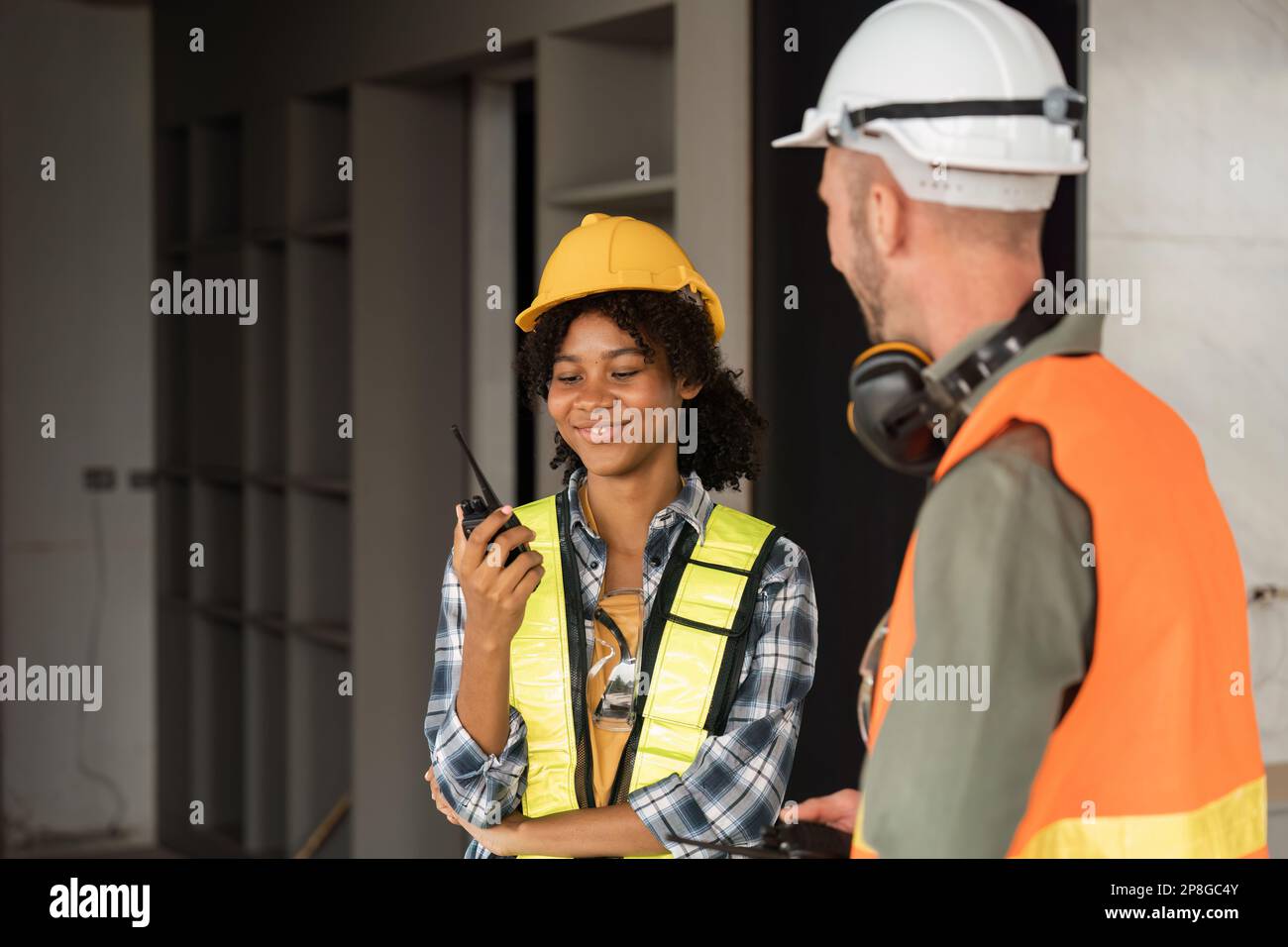 Female male engineers holding walkie talkie radios and inspecting ...