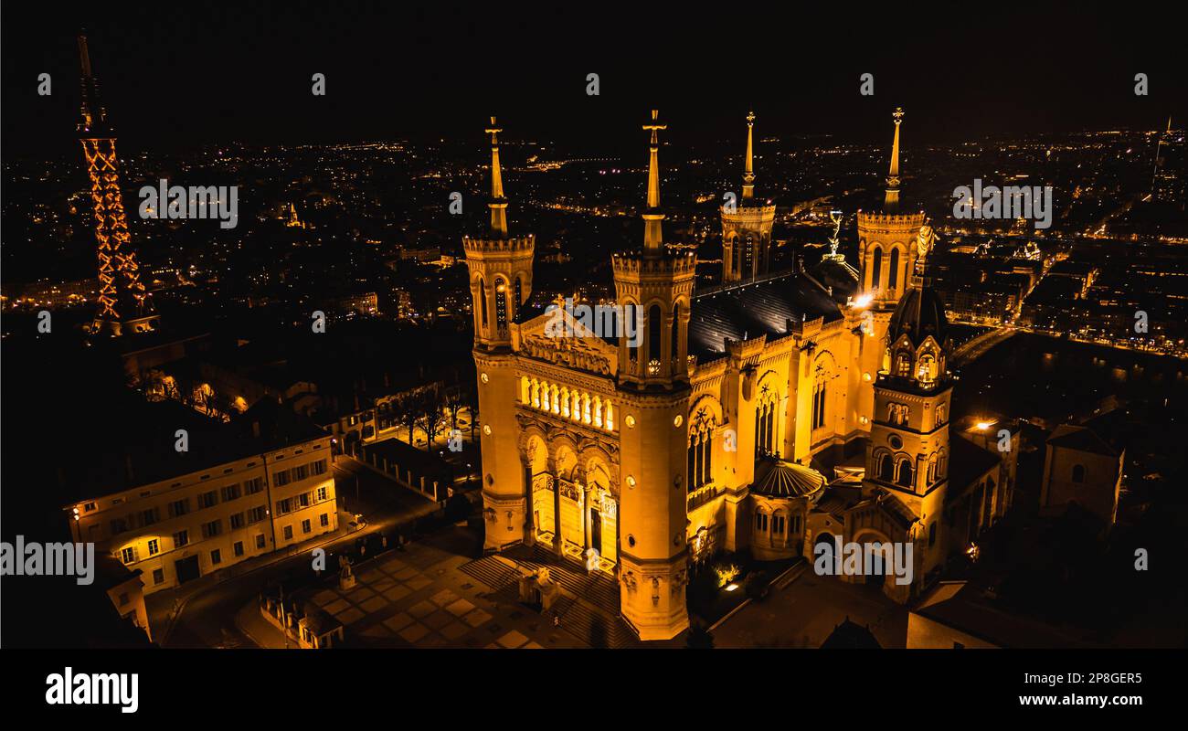 Panoramic aerial shot at night time of illuminated Basilica Notre Dame ...