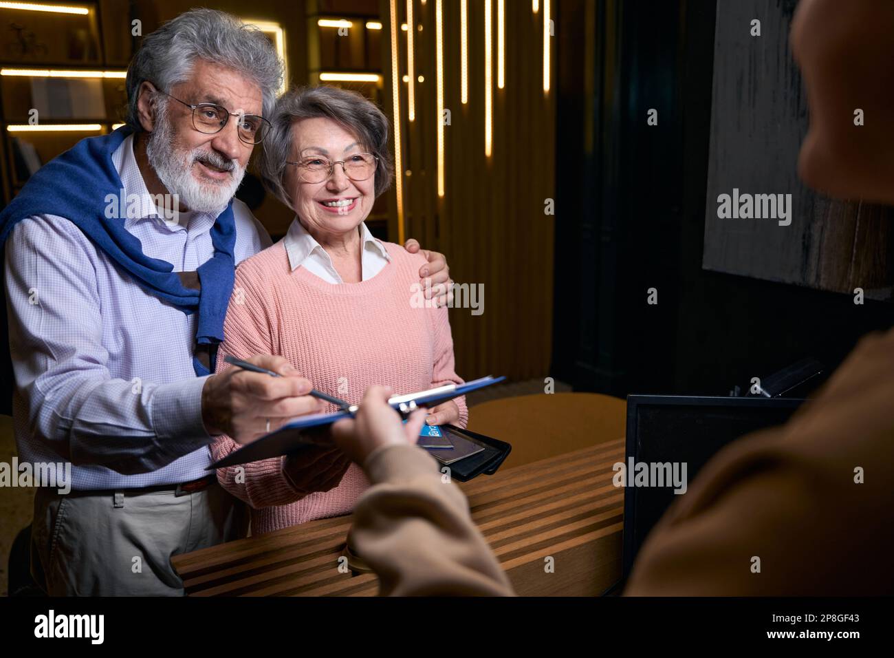 Traveling elderly couple checks into a hotel Stock Photo - Alamy