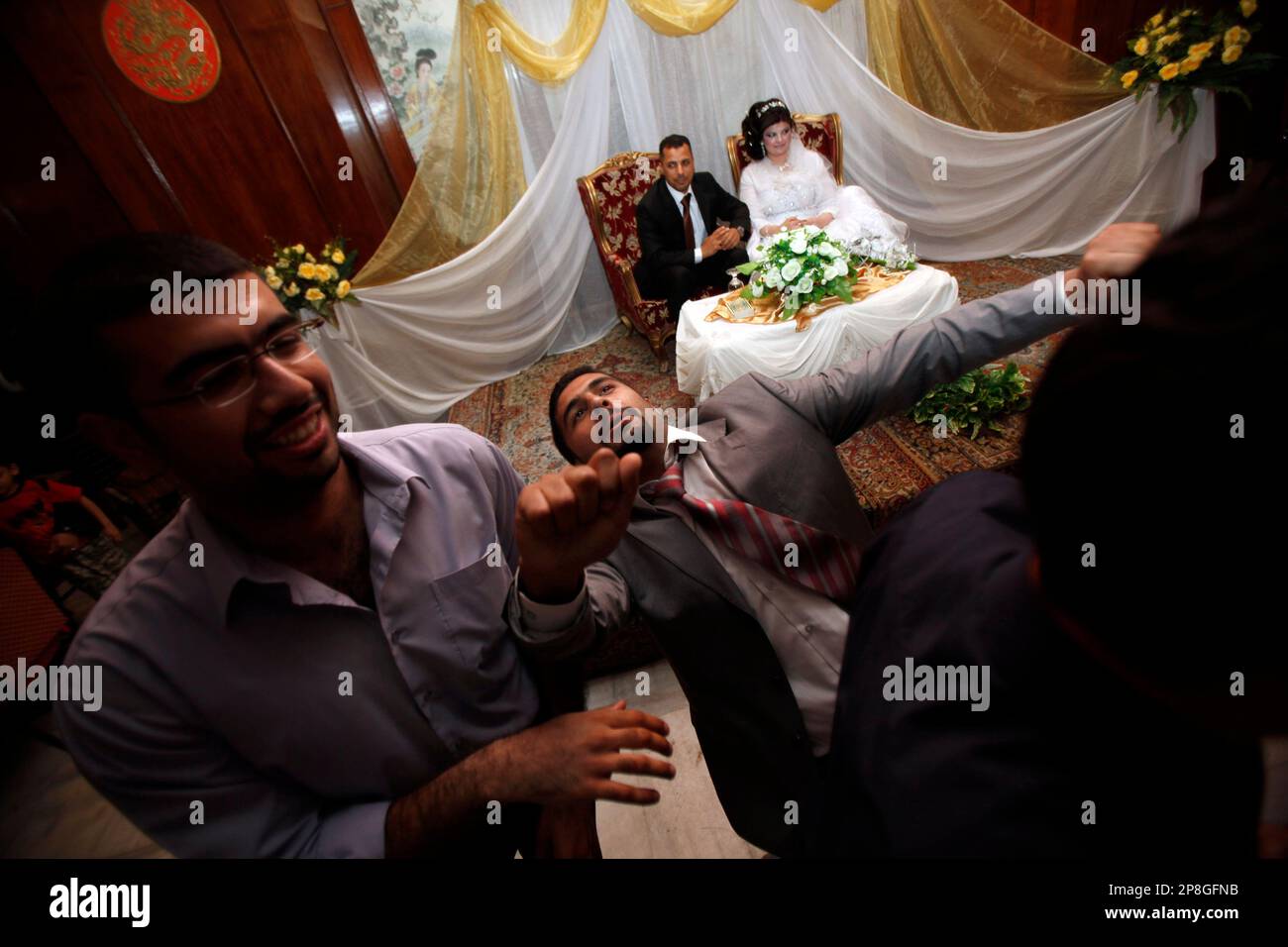Guests dance at the wedding of Dima Muhammed, 25, background right, and ...