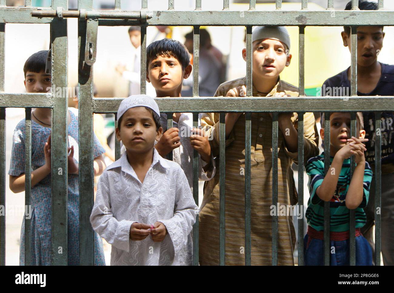 Children wait for their parents, who were casting their vote, outside a ...