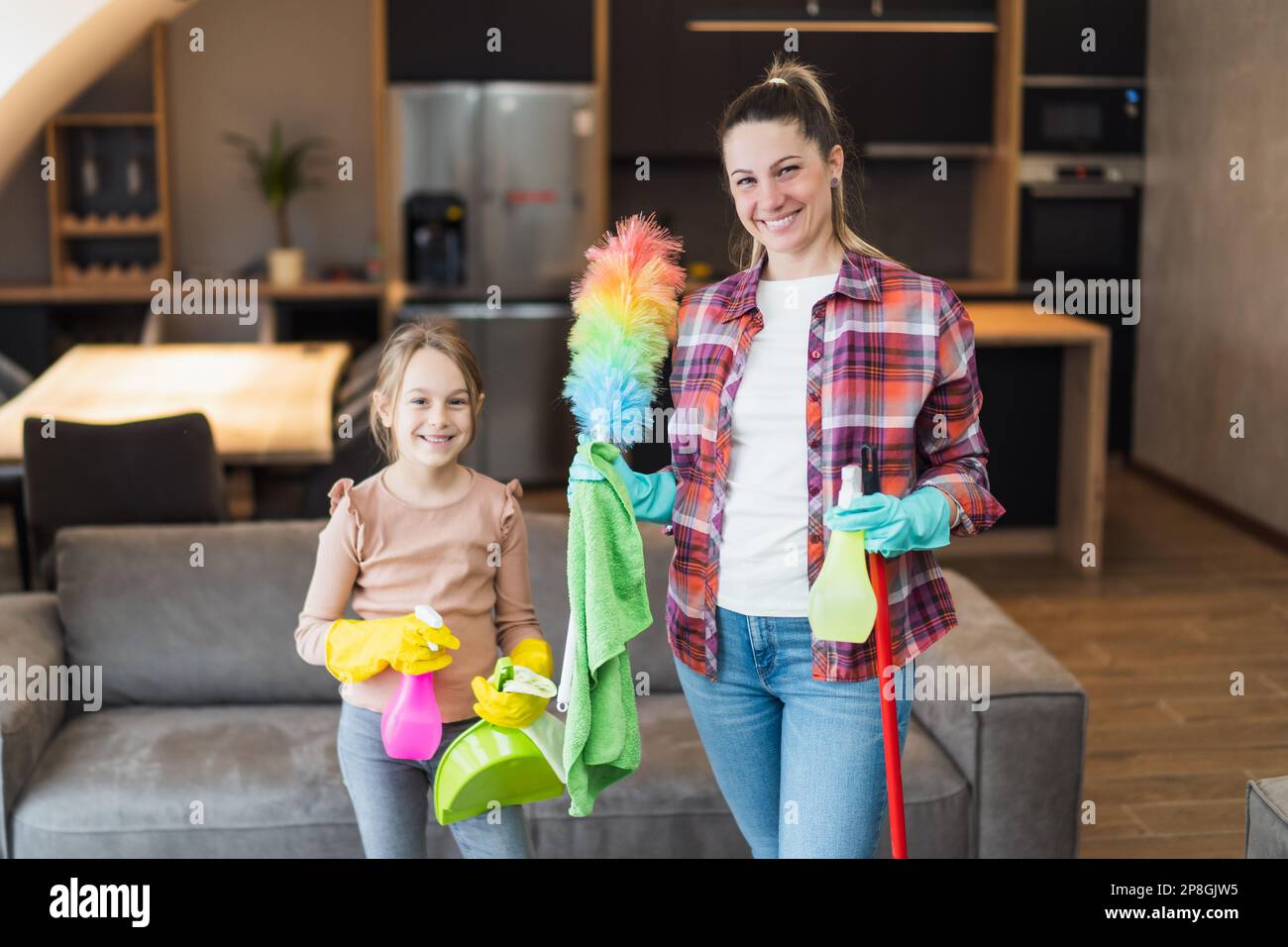 Happy mother and daughter cleaning house together Stock Photo - Alamy
