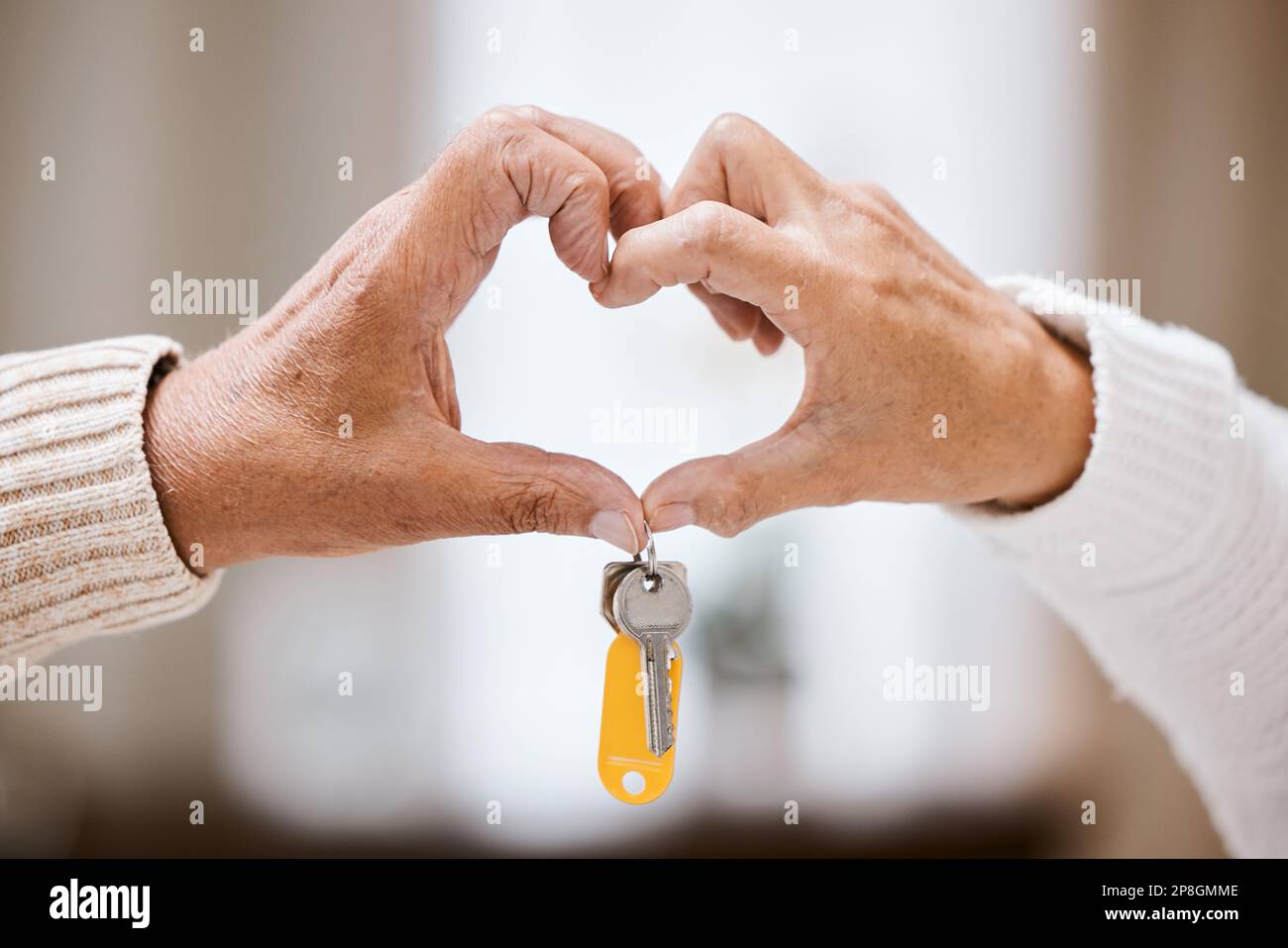 Senior couple, heart hands and keys for new home, success and bonding ...