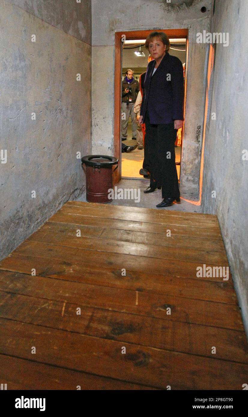 German Chancellor Angela Merkel enters a cell as she visits the prison ...