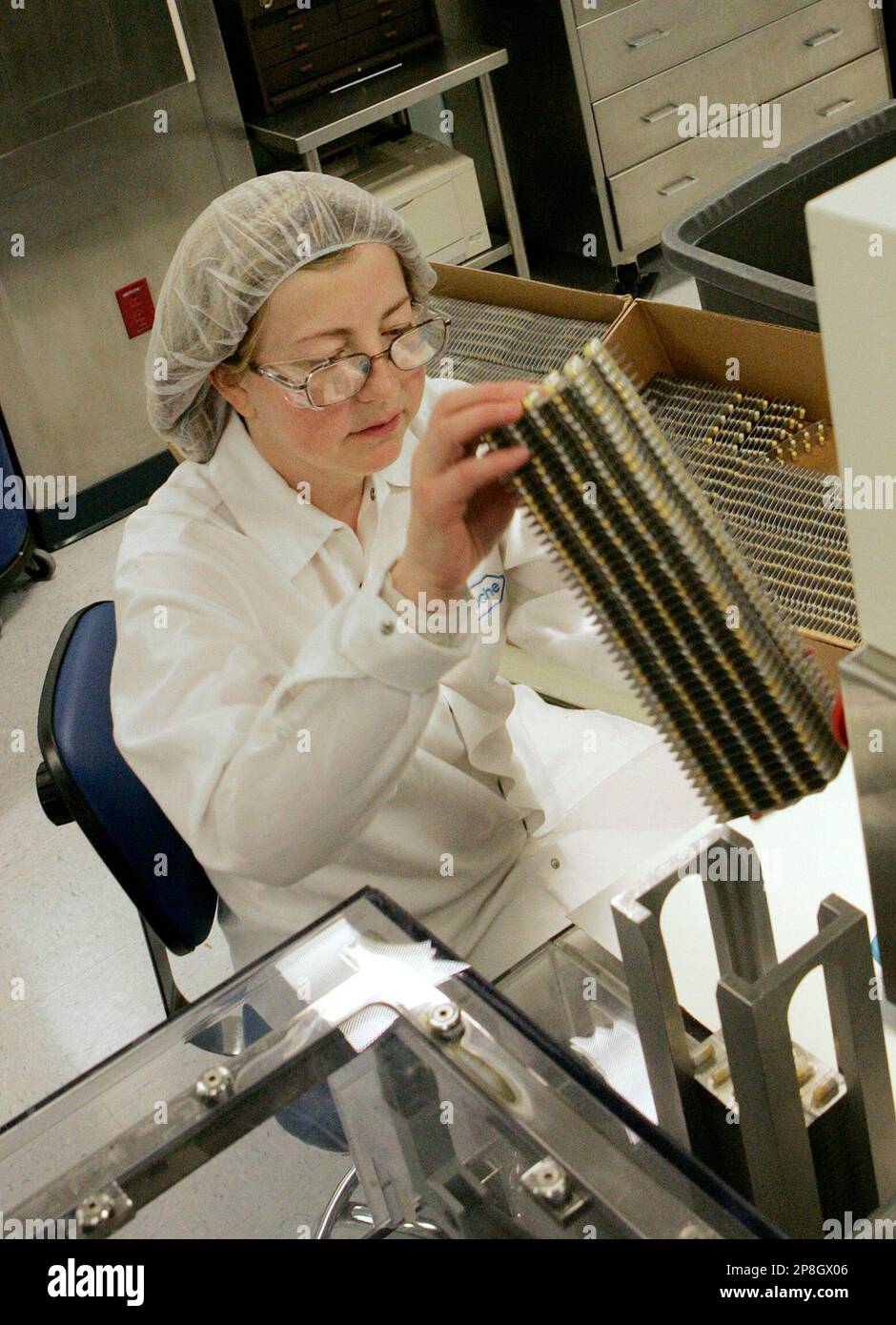 Margaret Oczkos loads Tamiflu ten-capsule packs into a cartoning ...
