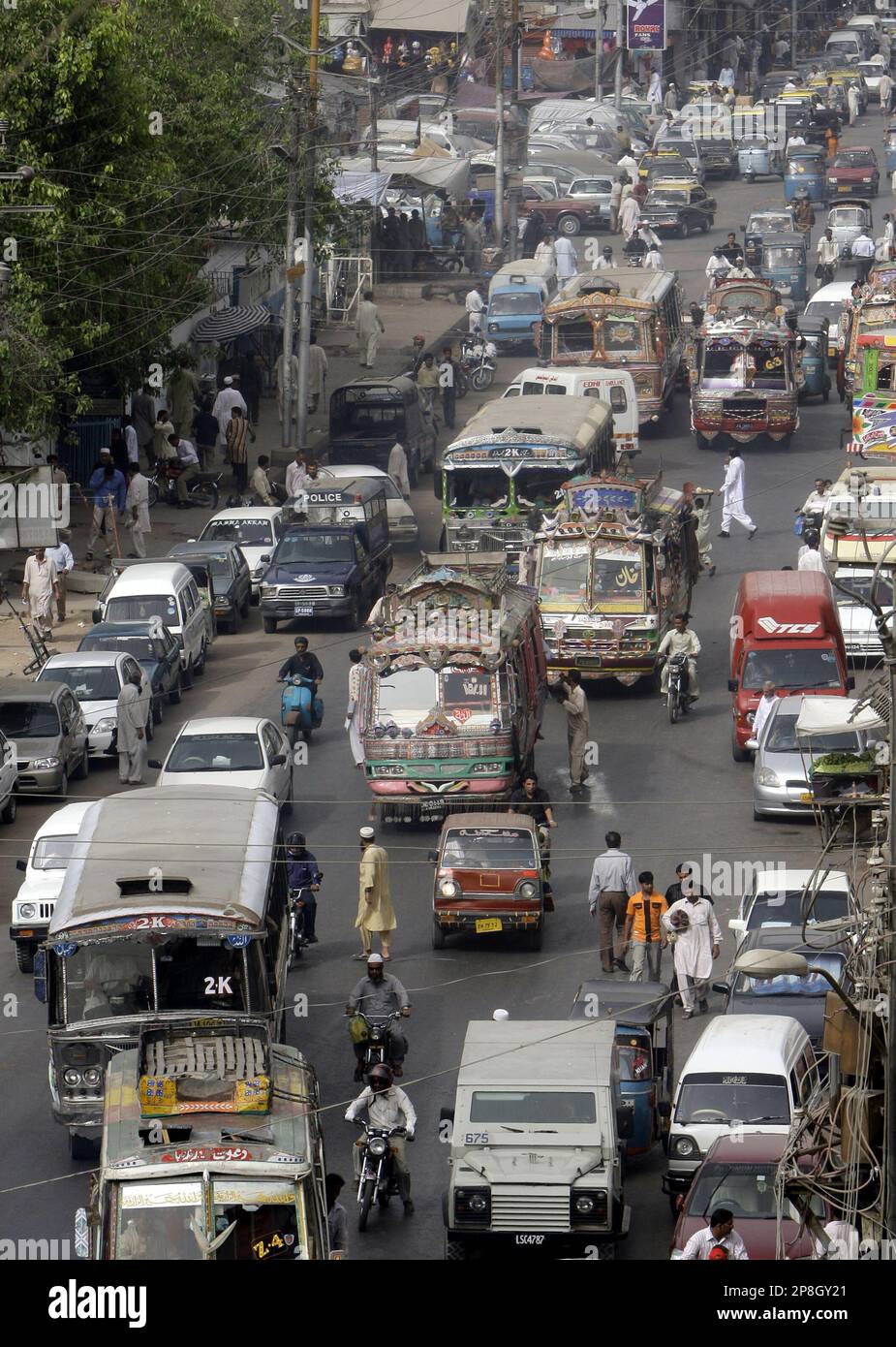 Buses make their way down a street outside Boulton Market in Karachi ...