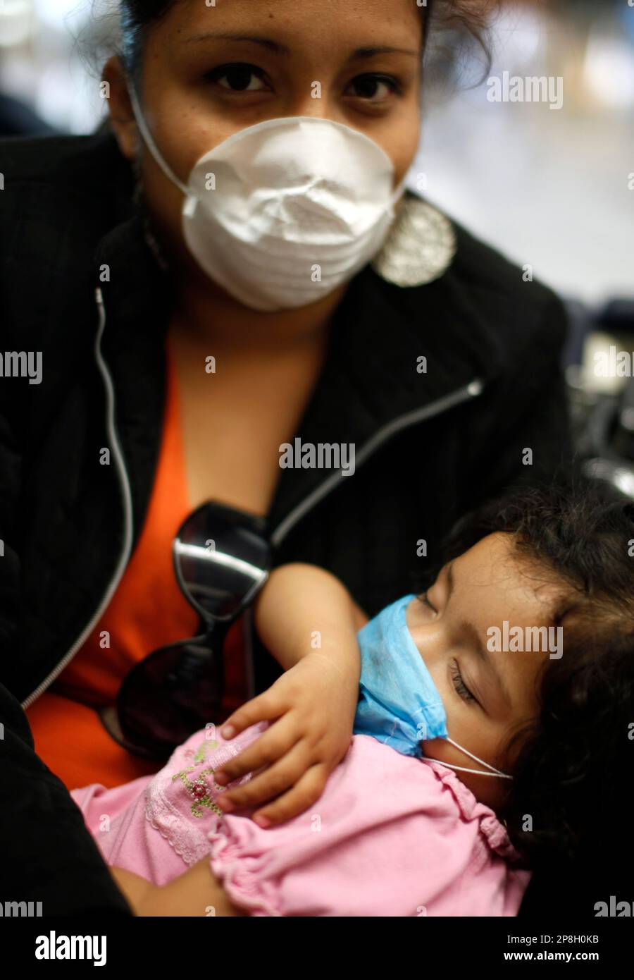 Sandra Martell holds her daughter Vanessa, both wearing masks as a ...