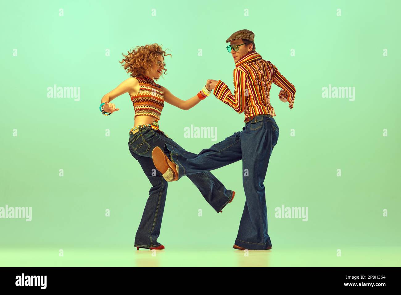 Two excited people, man and woman in retro style clothes dancing disco ...