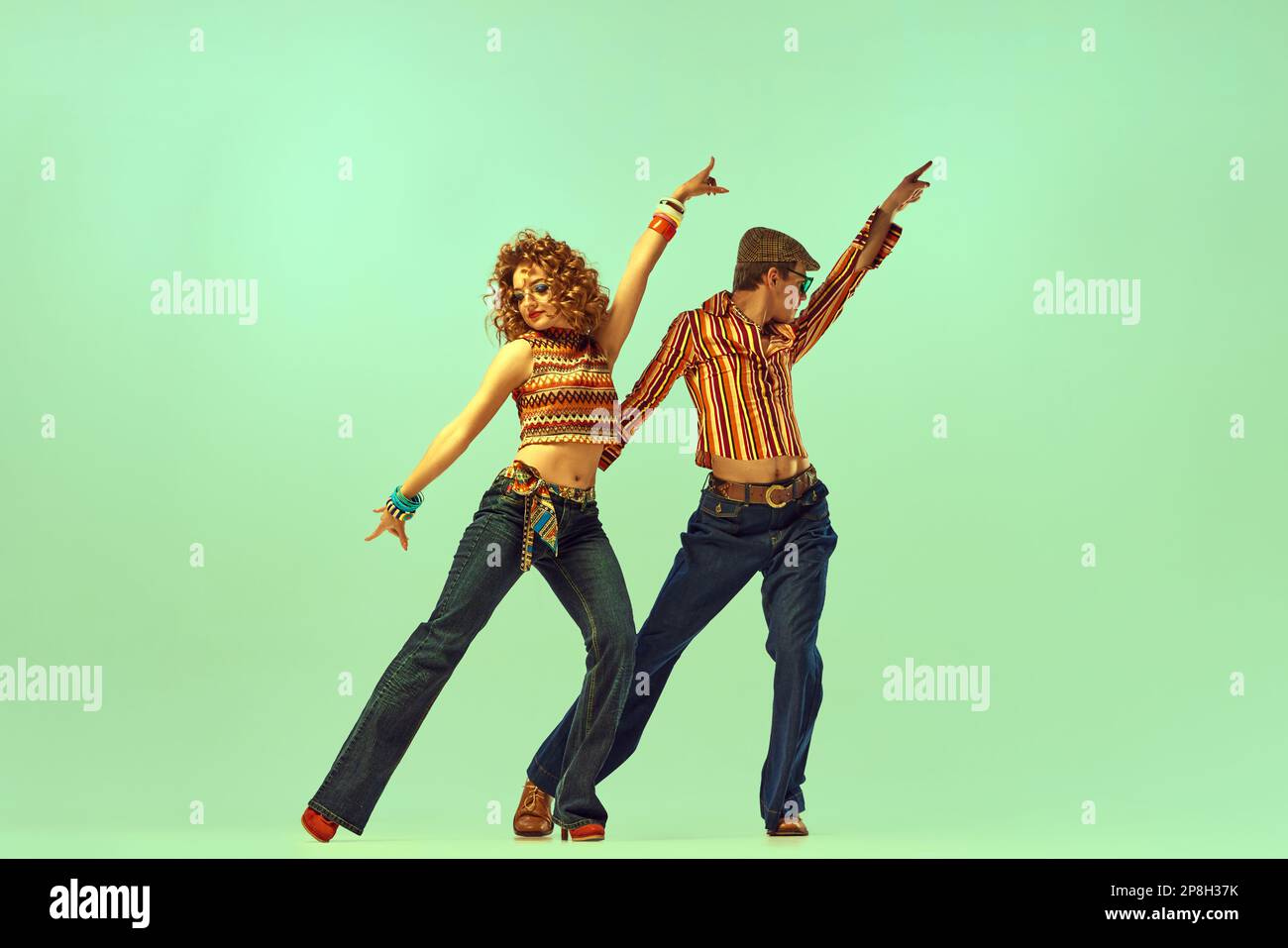 Two excited people, man and woman in retro style clothes dancing disco ...