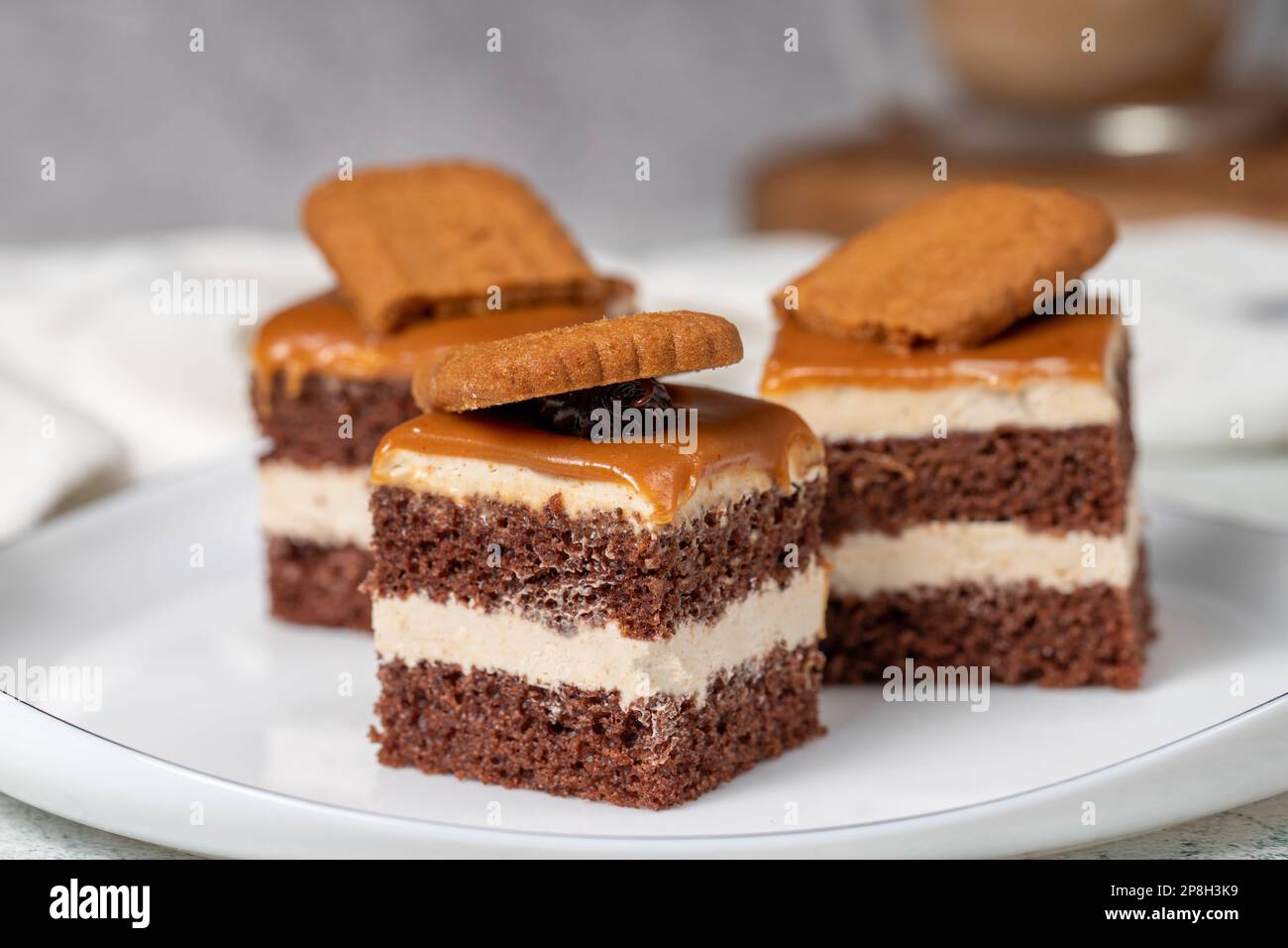 Small dessert cakes. Caramel petit four on a white plates in dark ...