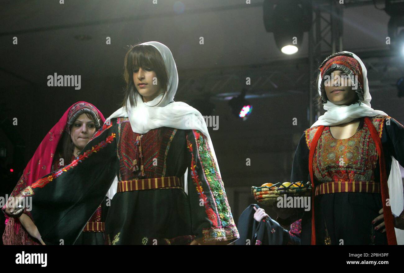 Models display traditional Palestinian costumes at a fashion show in ...
