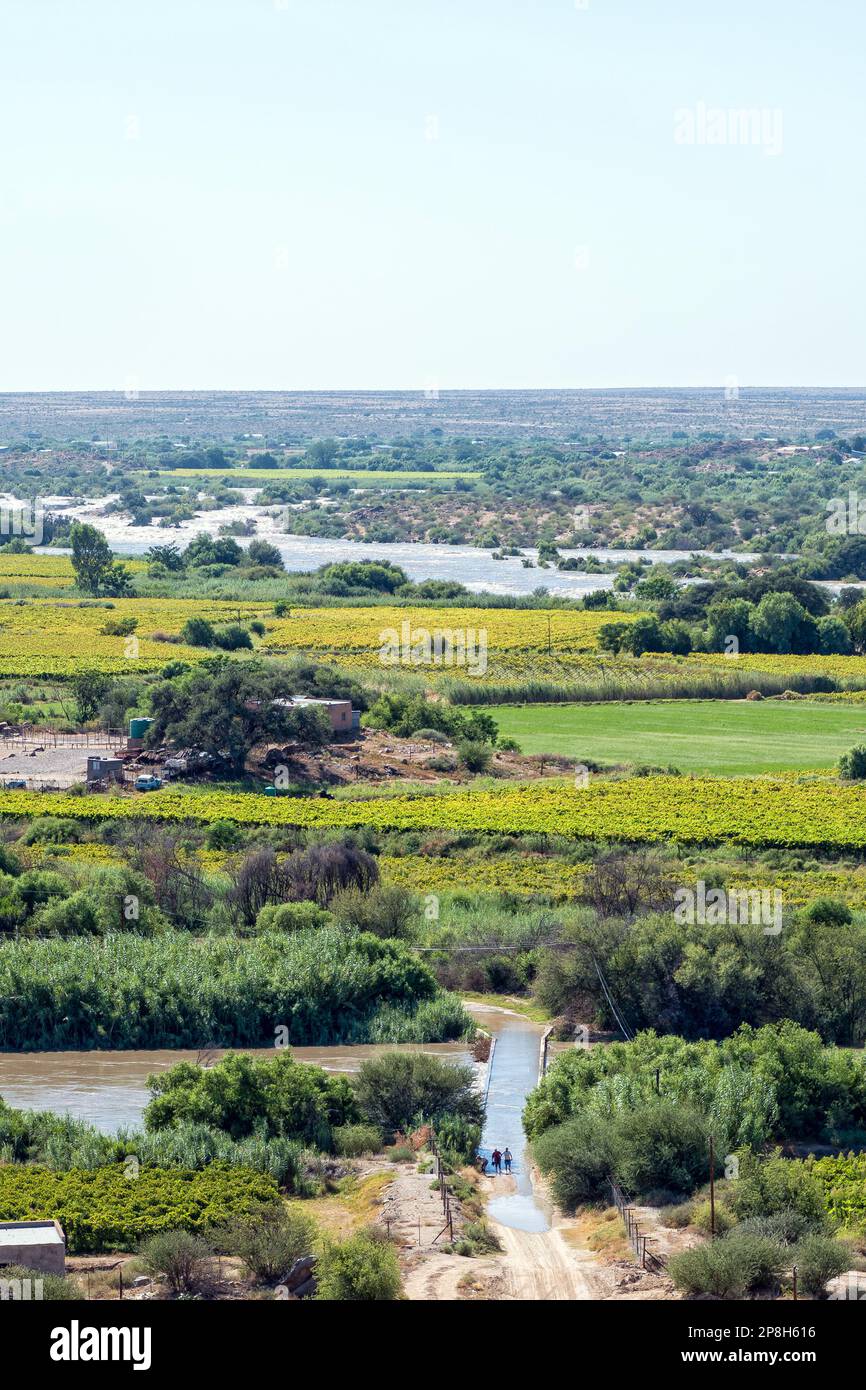 People crossing a flooded bridge over a channel of the flooded Orange ...