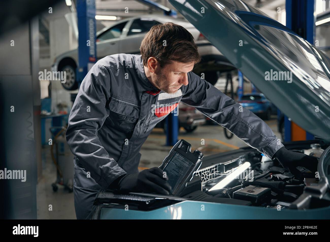 Male in overalls working near the automobile Stock Photo - Alamy