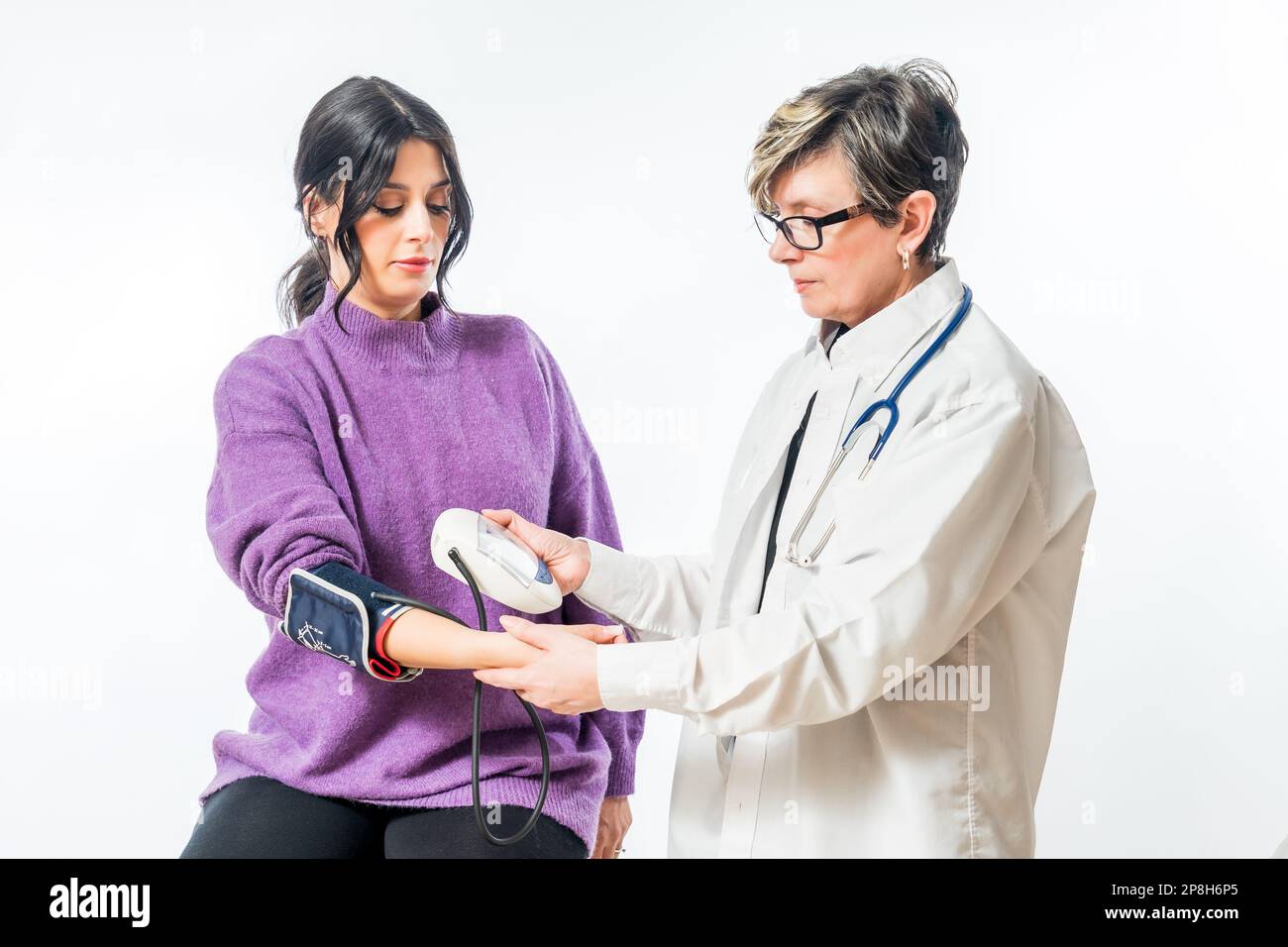 A woman is having her blood pressure checked by a medical professional ...
