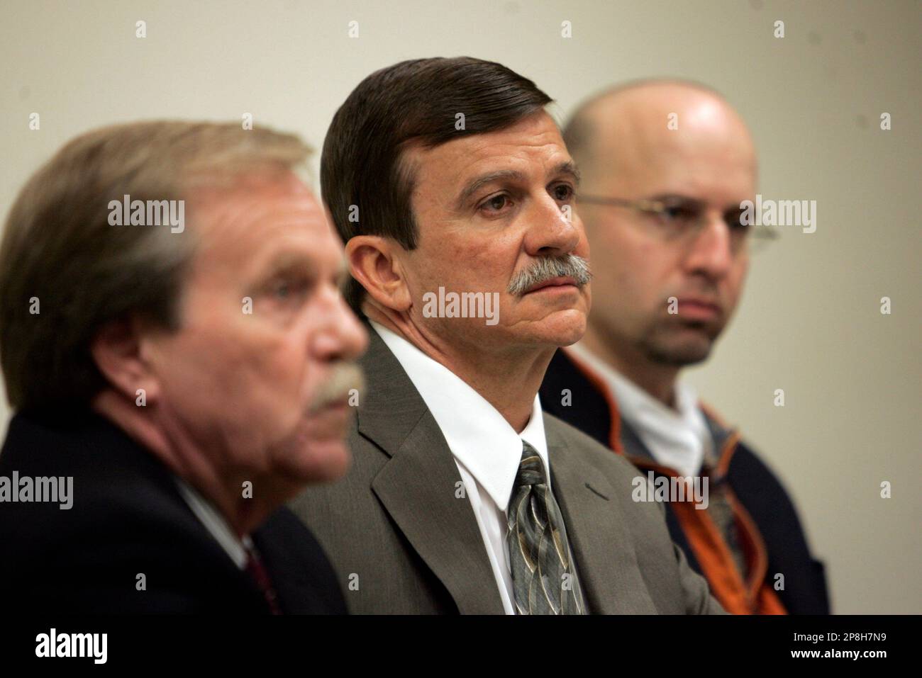 Flanked by his lawyers, Michael Devlin, left, and John Geida, right ...