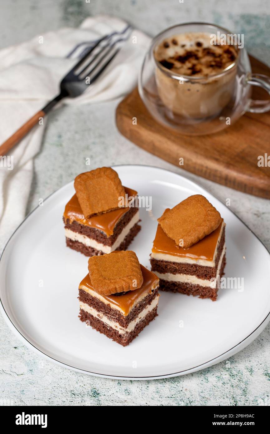 Small dessert cakes. Caramel petit four on a white plates in dark ...