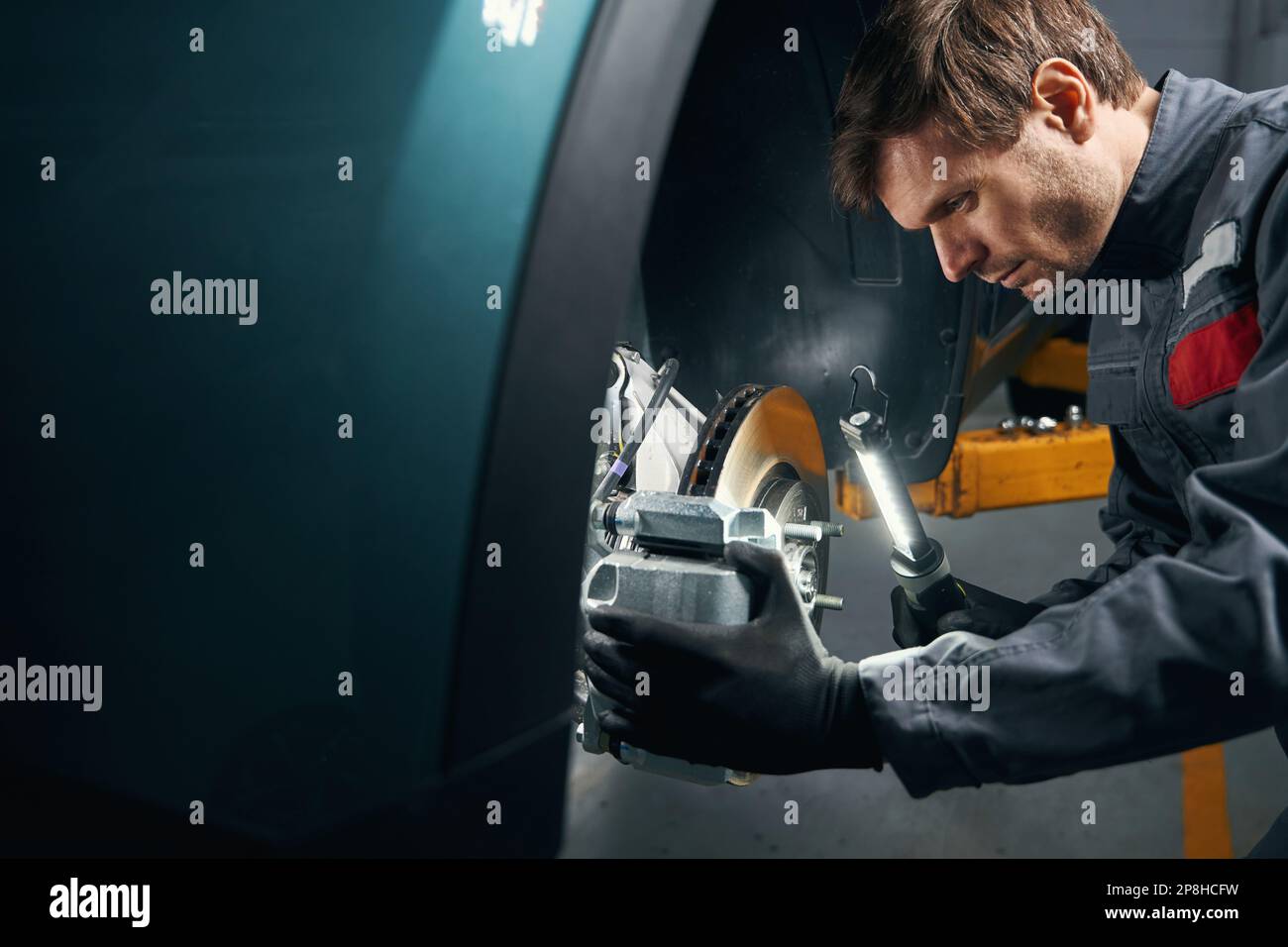 Male doing inspection of the brake system Stock Photo - Alamy