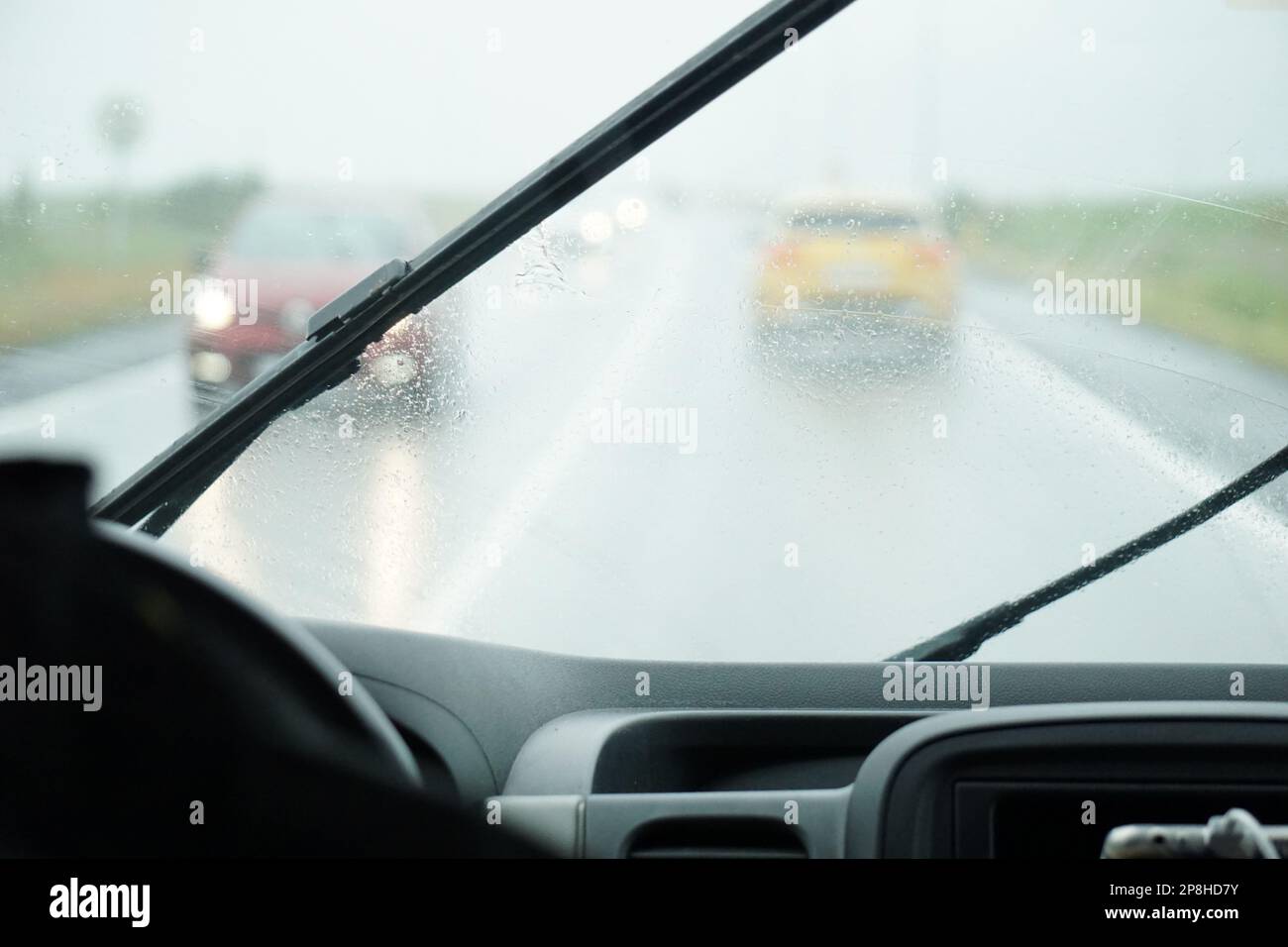 Driving a car in the rain with activated windshield wipers Stock Photo ...